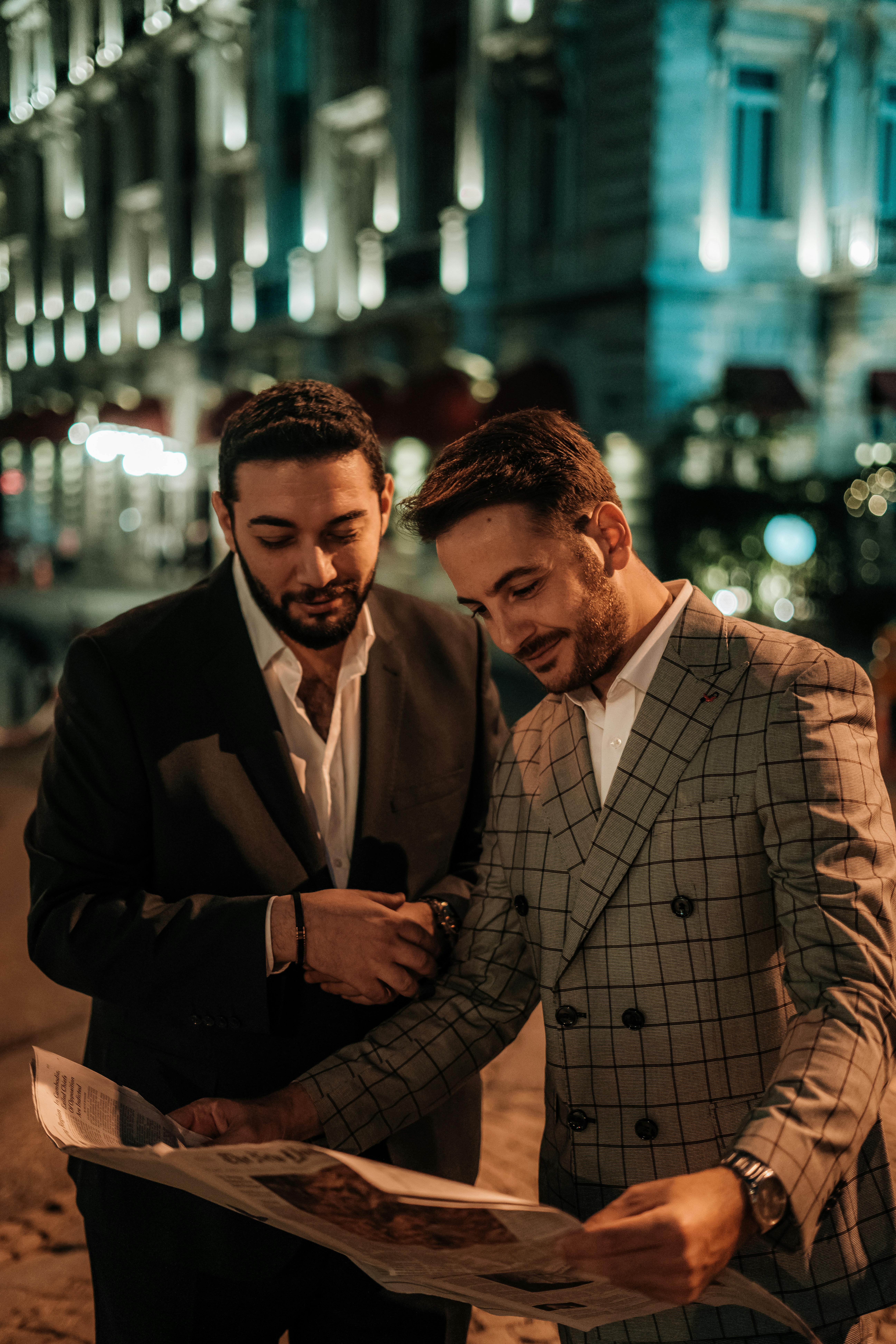 Two Men Reading a News Paper in the Street · Free Stock Photo