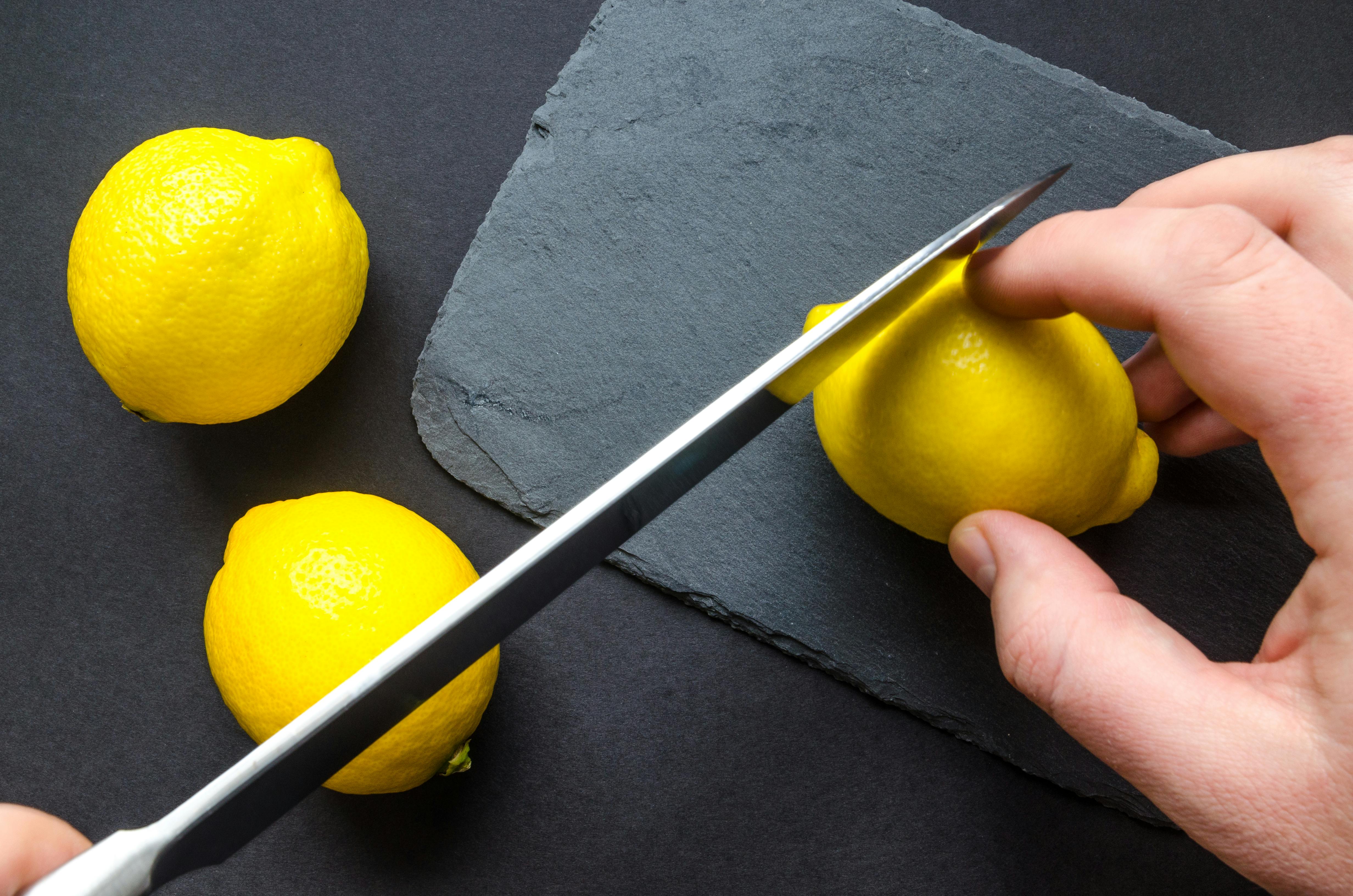 Human Slicing Yellow Lemon · Free Stock Photo