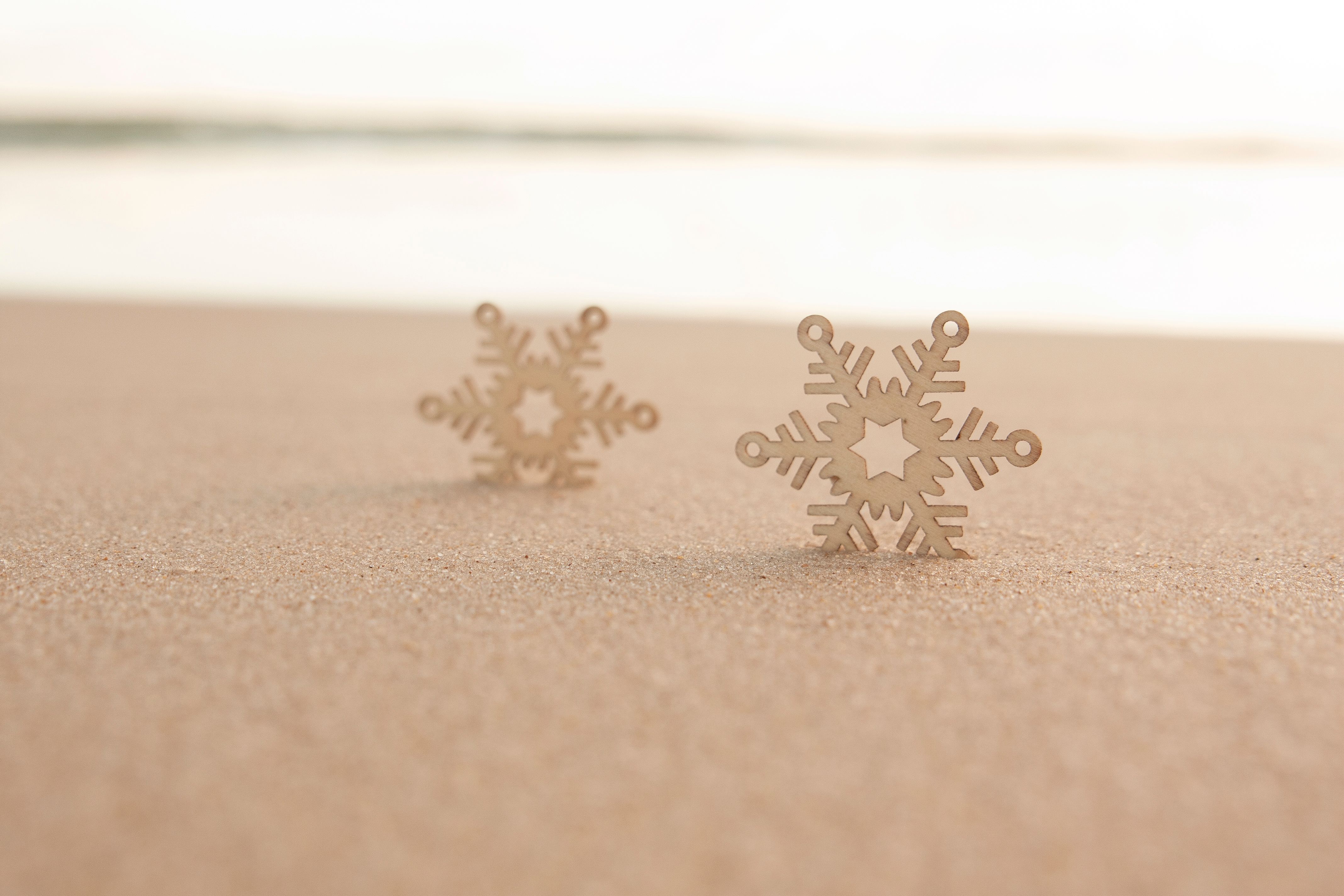 Wooden Snowflake Shapes Fixed in Sand · Free Stock Photo