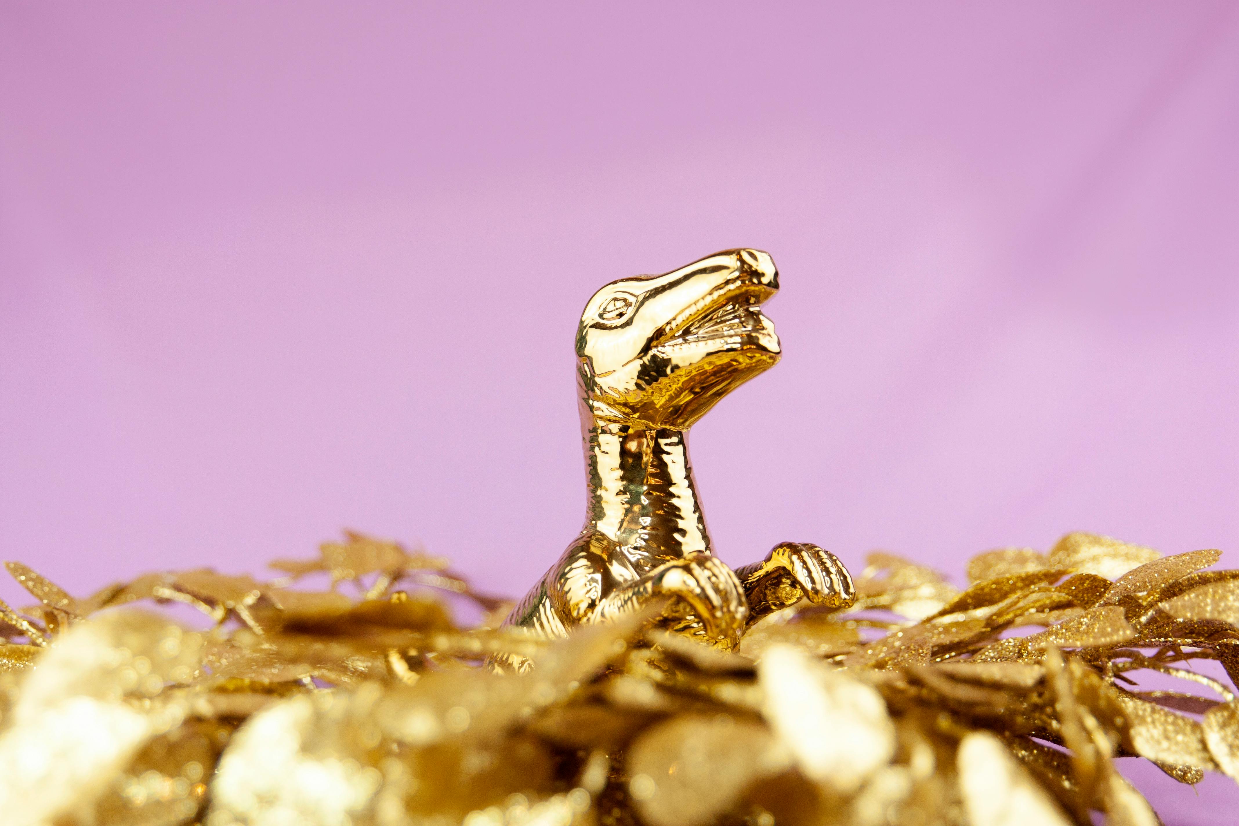 A Golden Figurine of a Dinosaur · Free Stock Photo