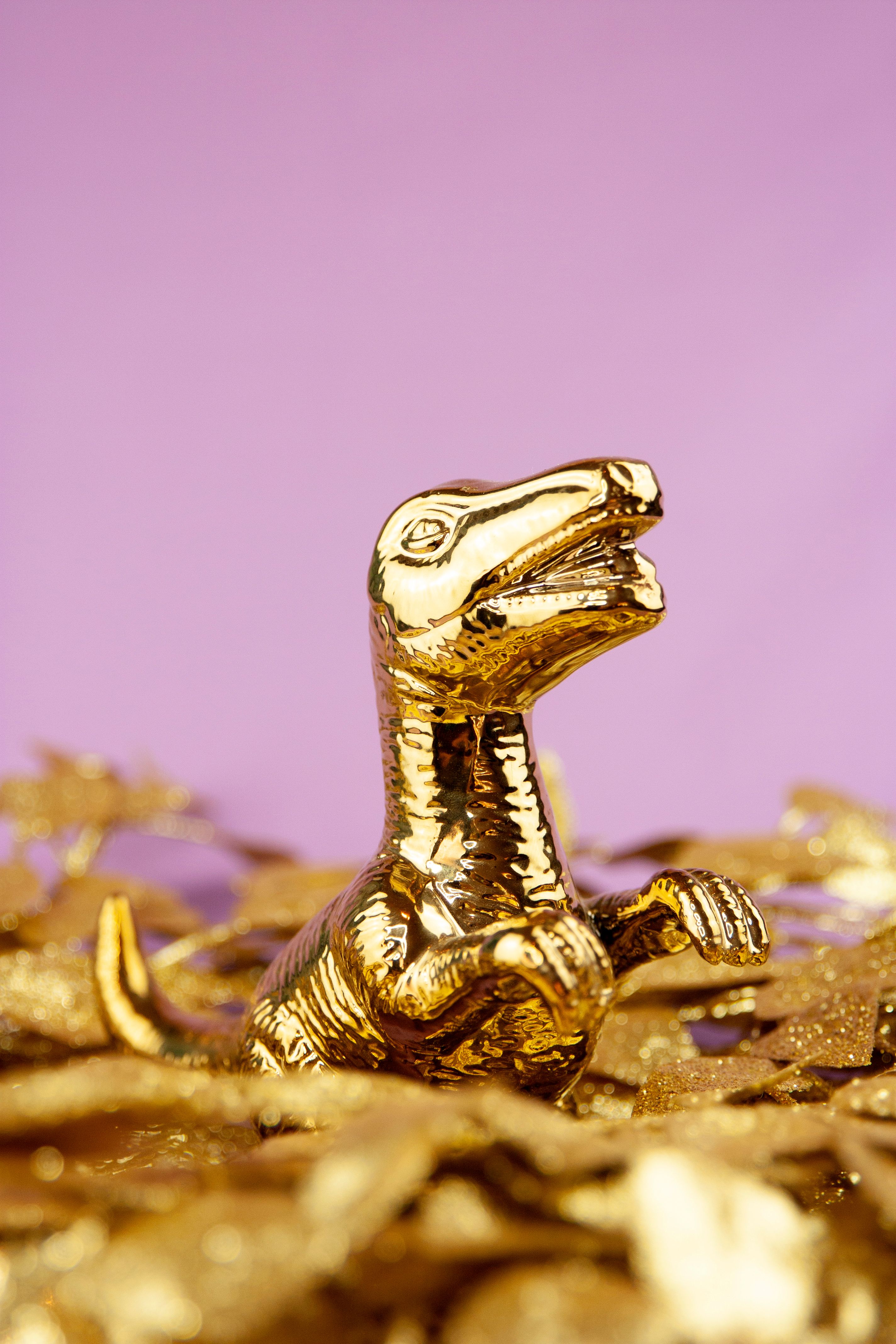 A Golden Dinosaur Figure on a Gold Wreath · Free Stock Photo