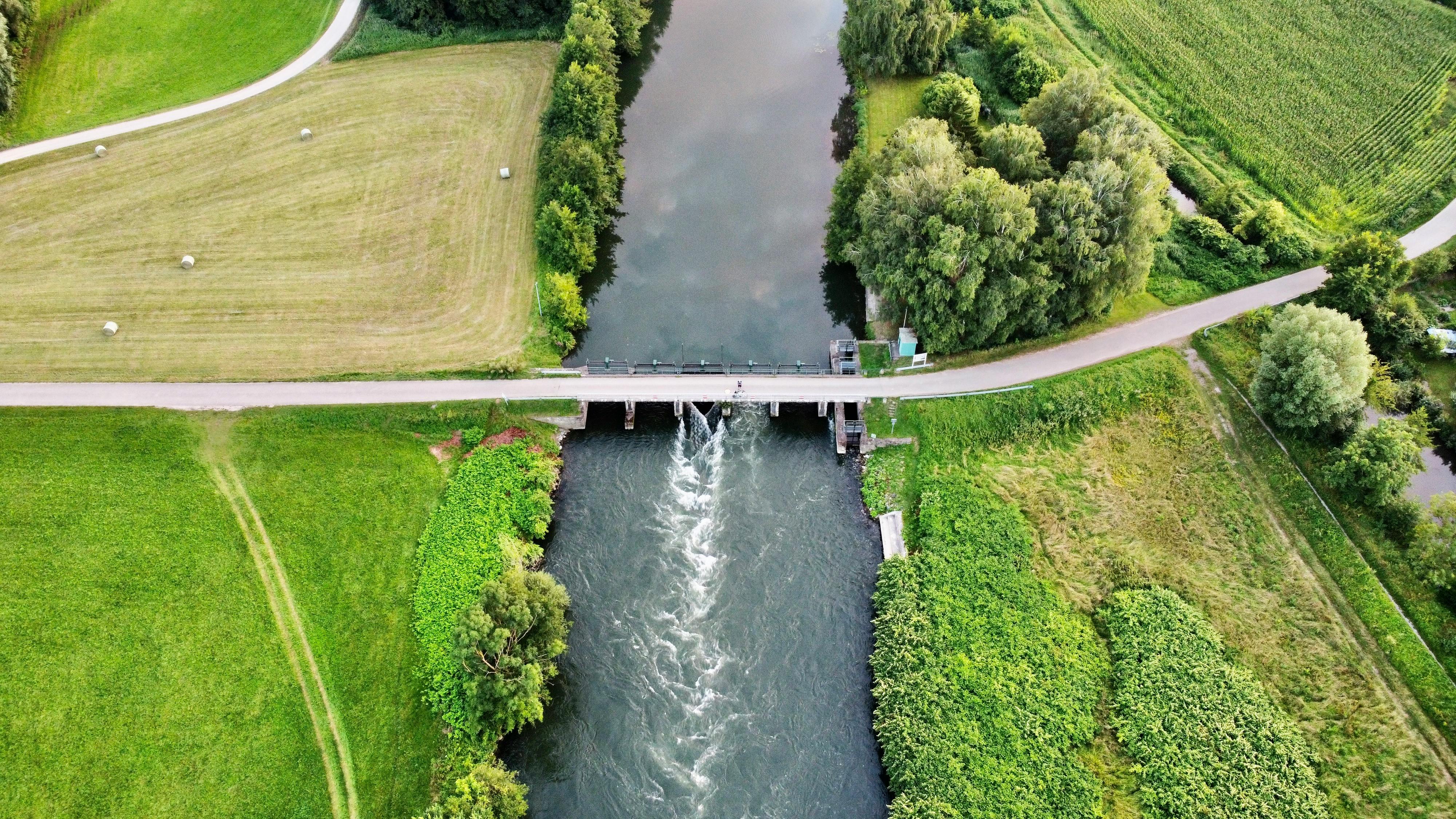 A Bridge Crossing the River in an Agricultural Land · Free Stock Photo
