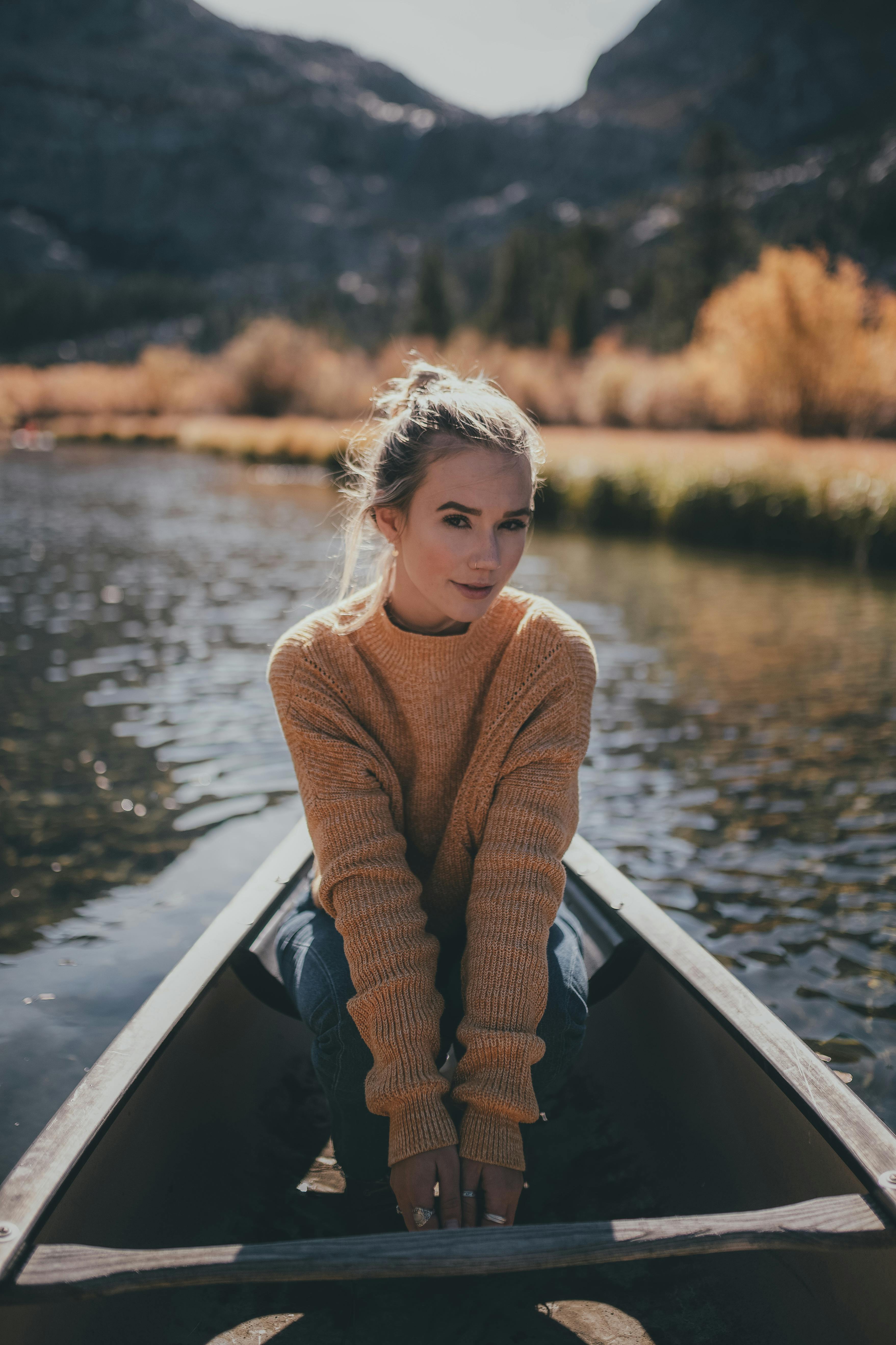 Woman in Brown Sweater Riding on Boat · Free Stock Photo