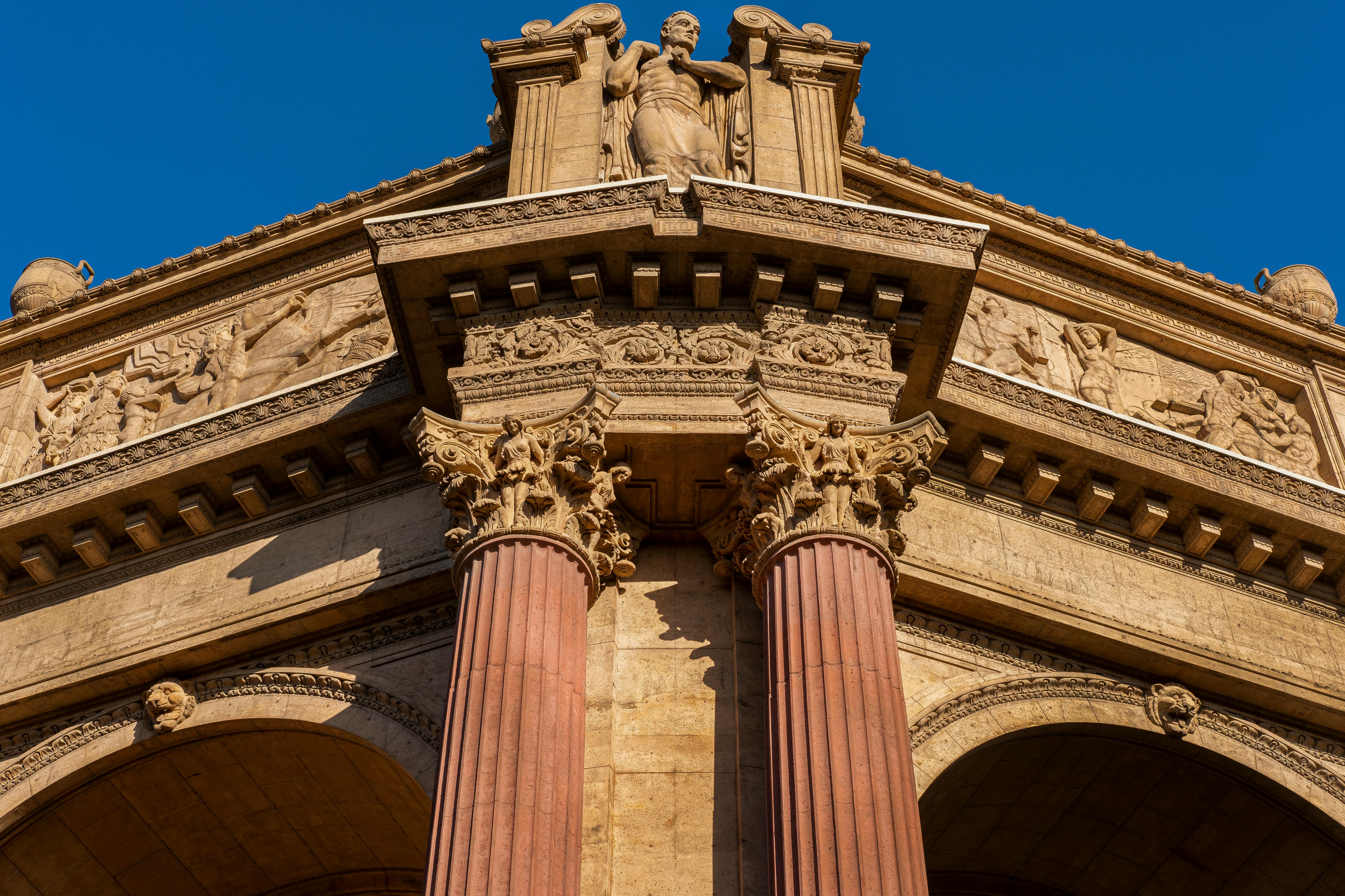 A Sculpture of a Man Above the Columns with Carvings · Free Stock Photo