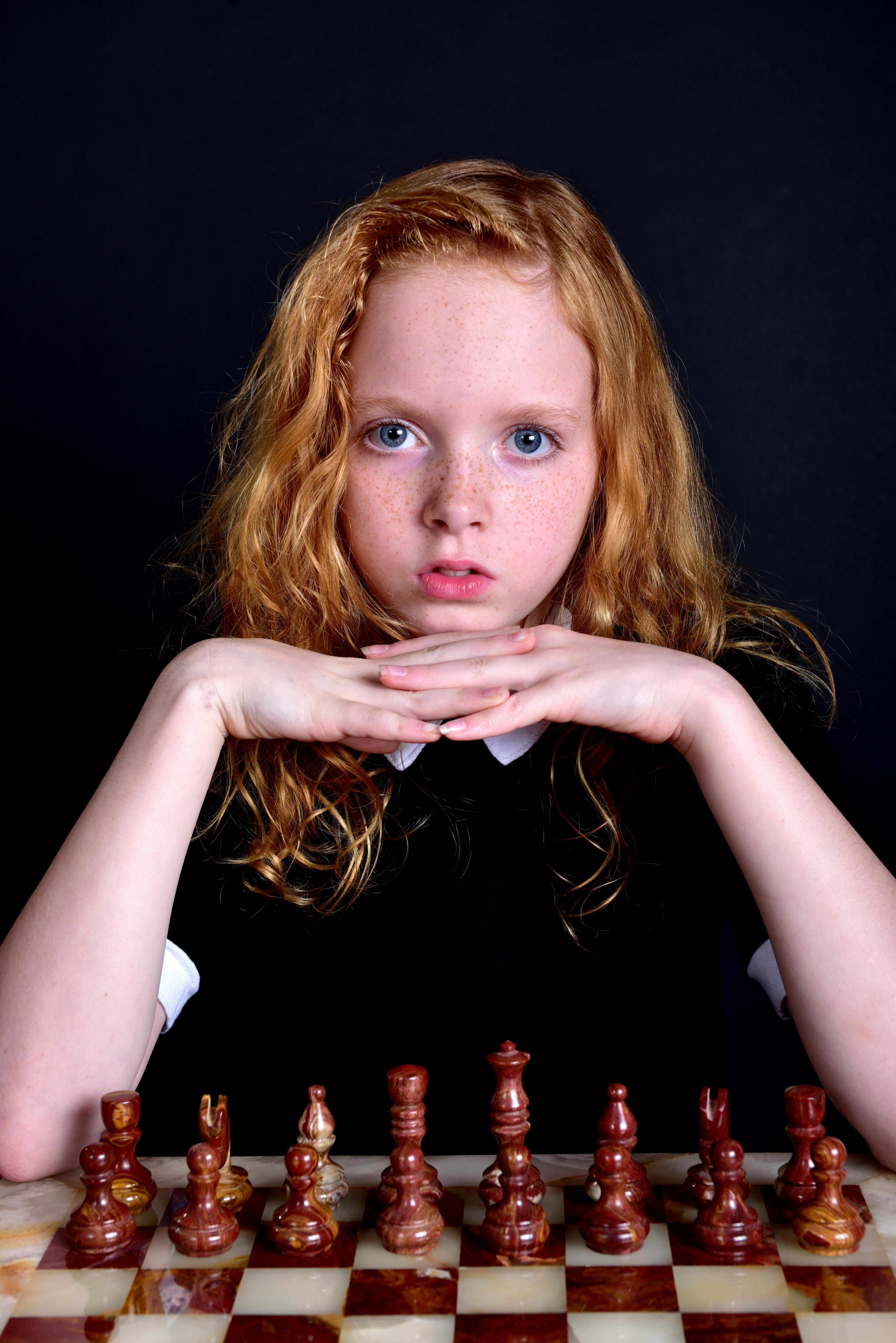 A Girl Sitting at the Table with Chess Pieces · Free Stock Photo