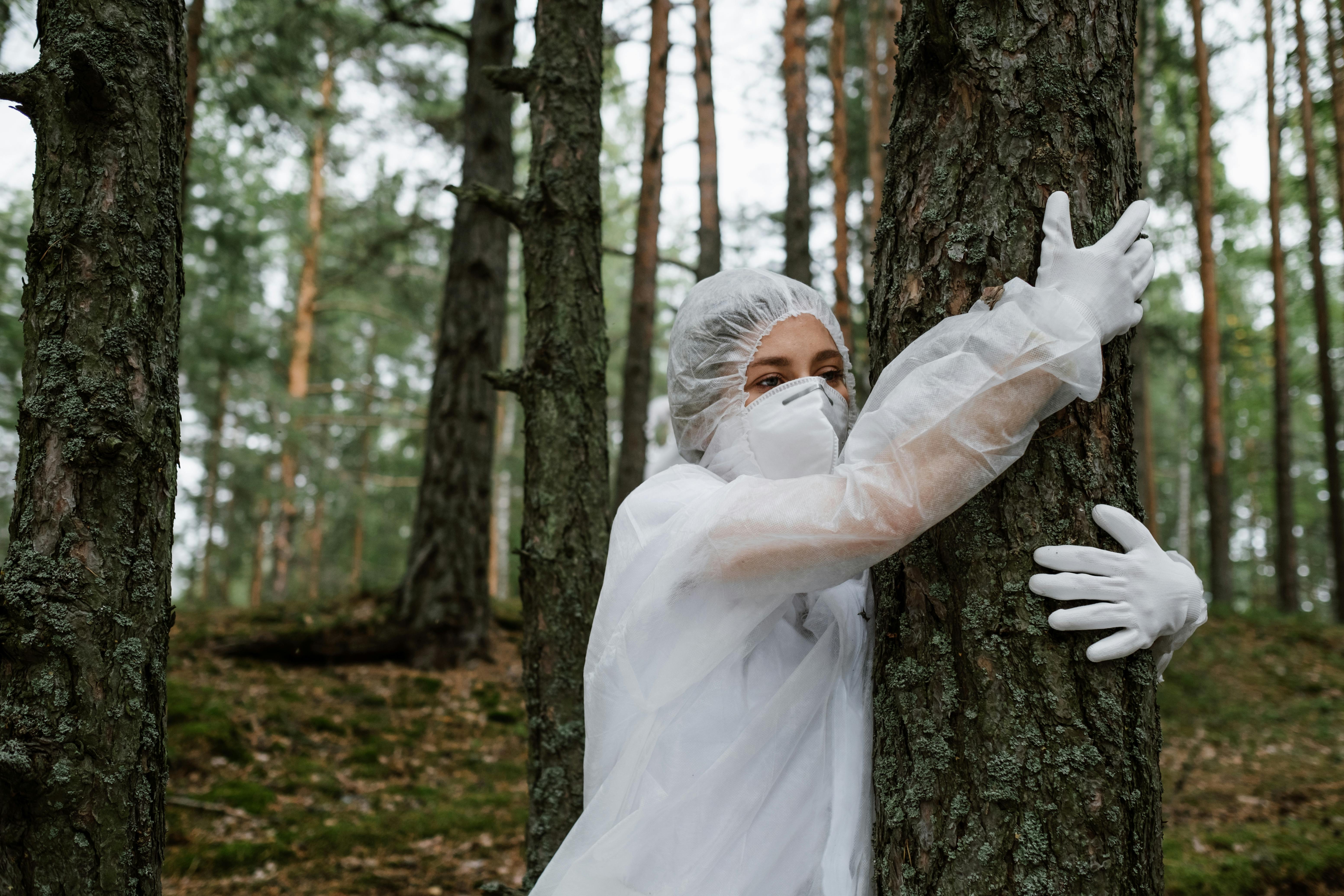 Person in Full Personal Protective Suit Hugging a Tree Trunk · Free ...