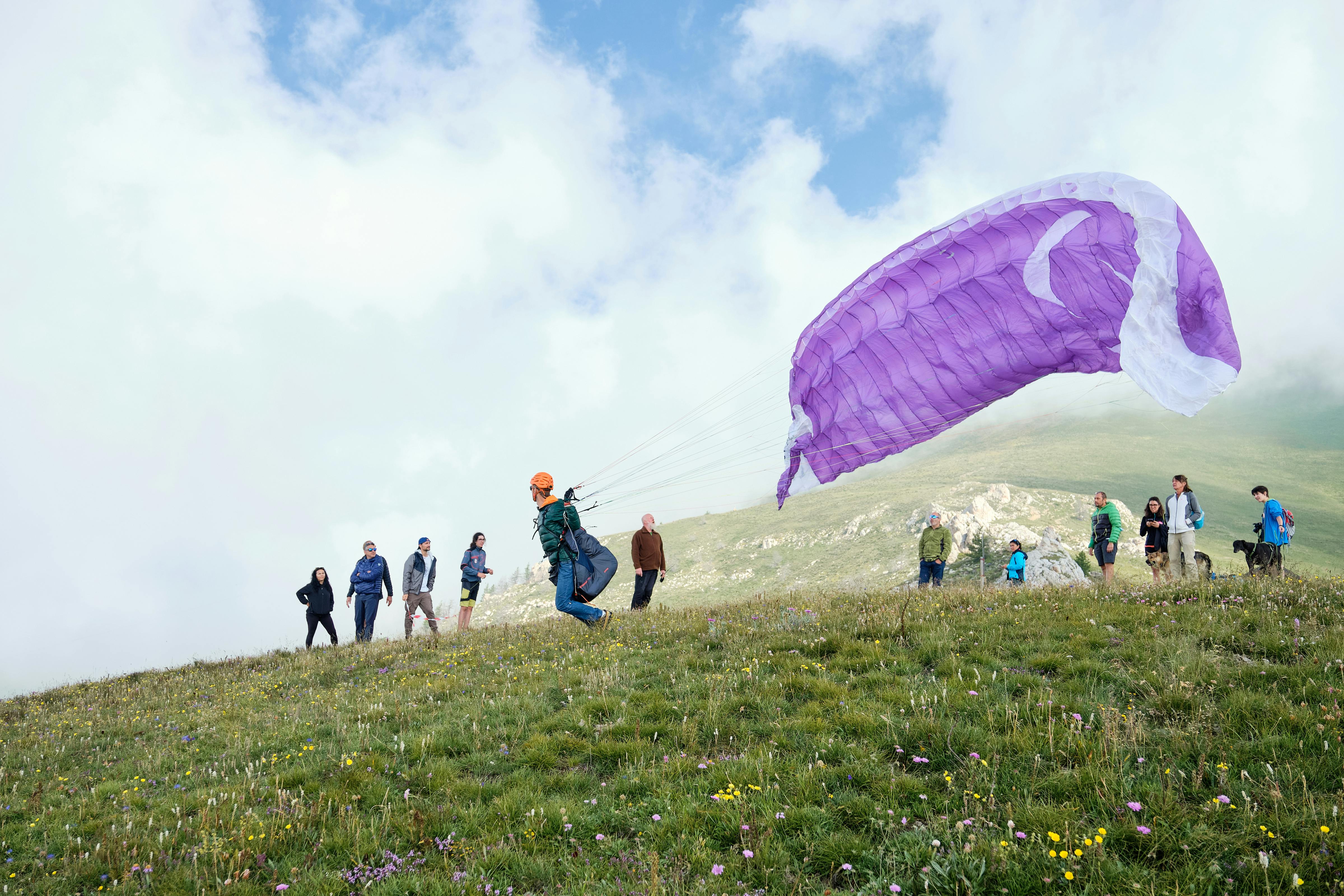 People Watching a Paraglider Take Off · Free Stock Photo