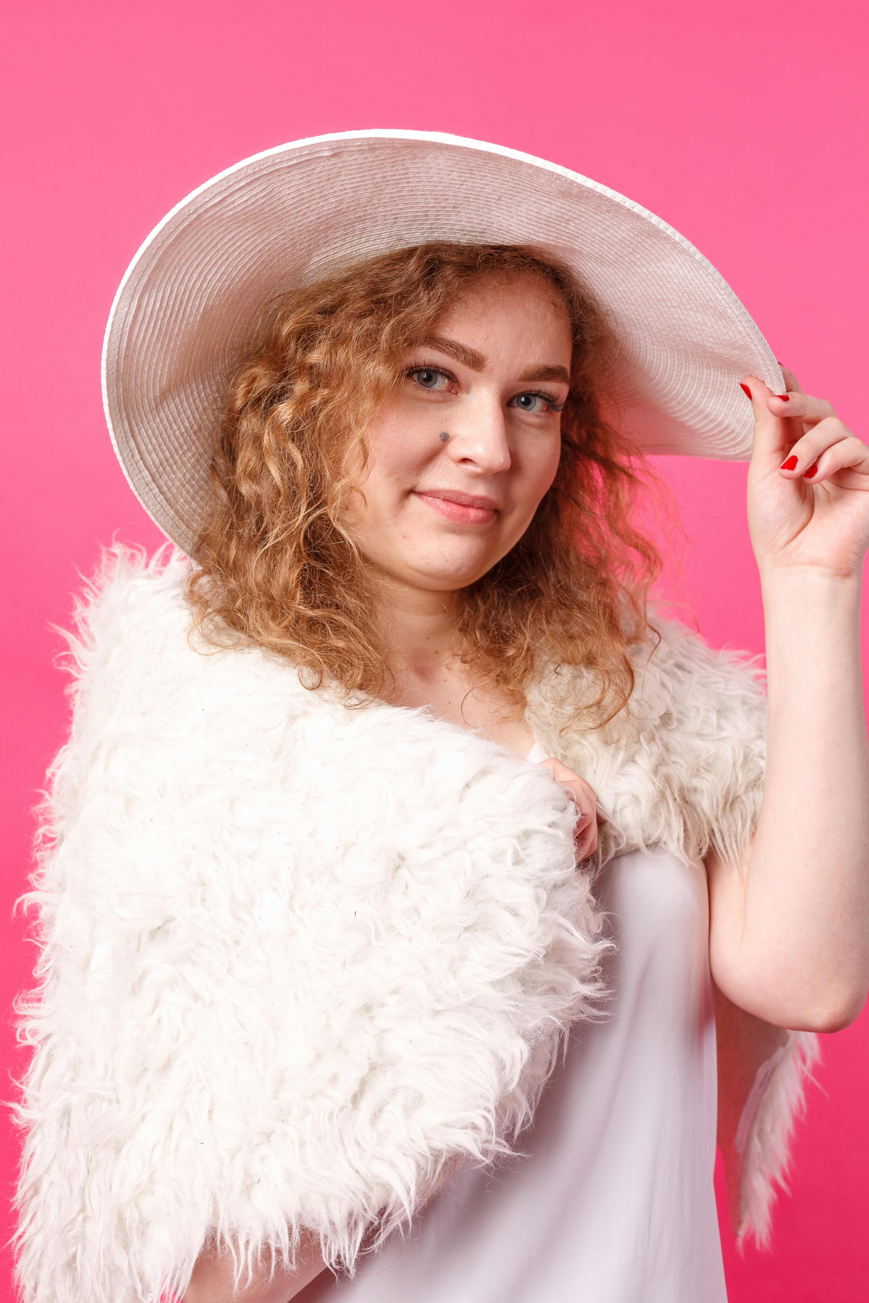Woman in Pink Background Holding a Fur Cloth · Free Stock Photo