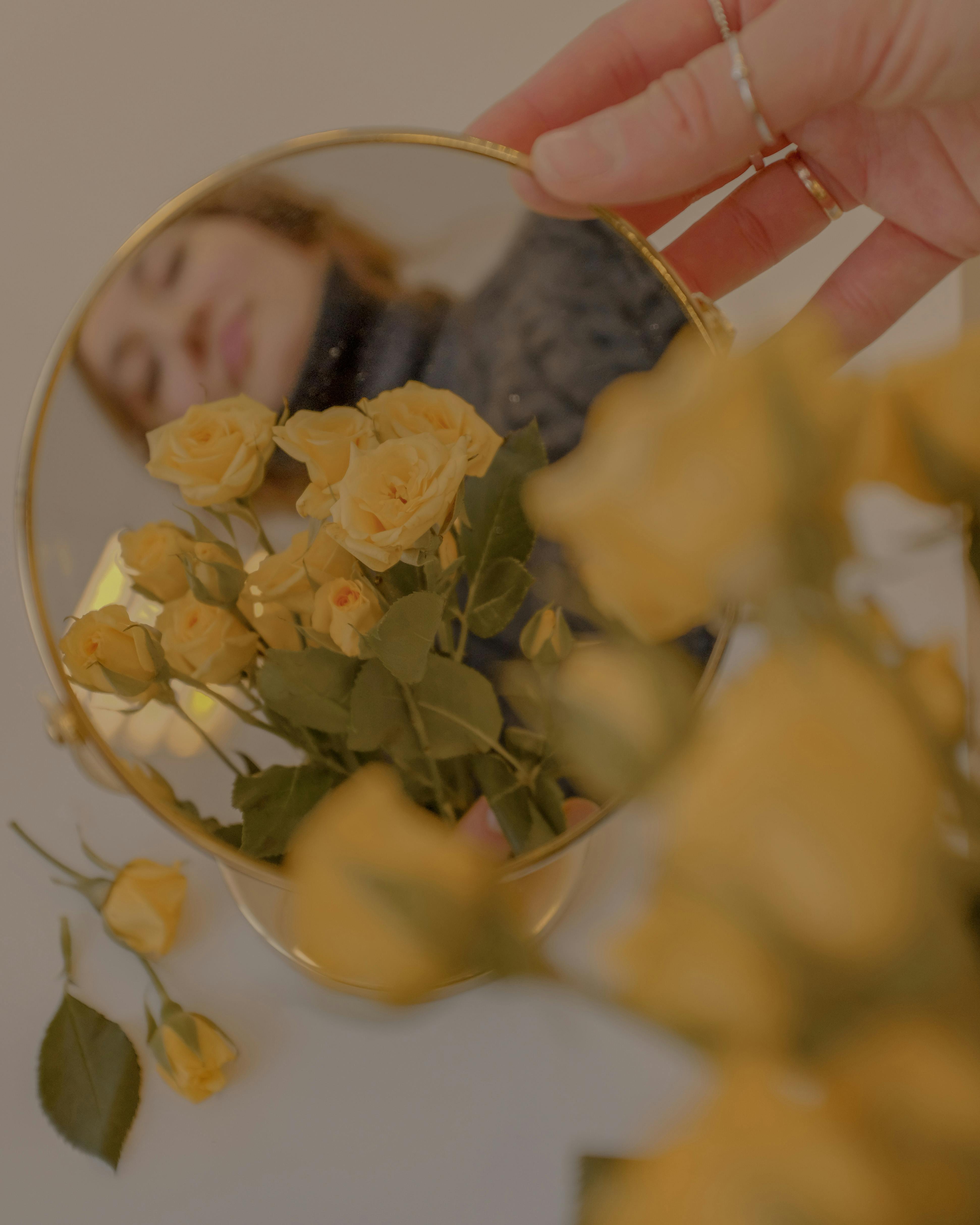 Hand Holding a Mirror with a Reflection of Yellow Flowers · Free Stock ...