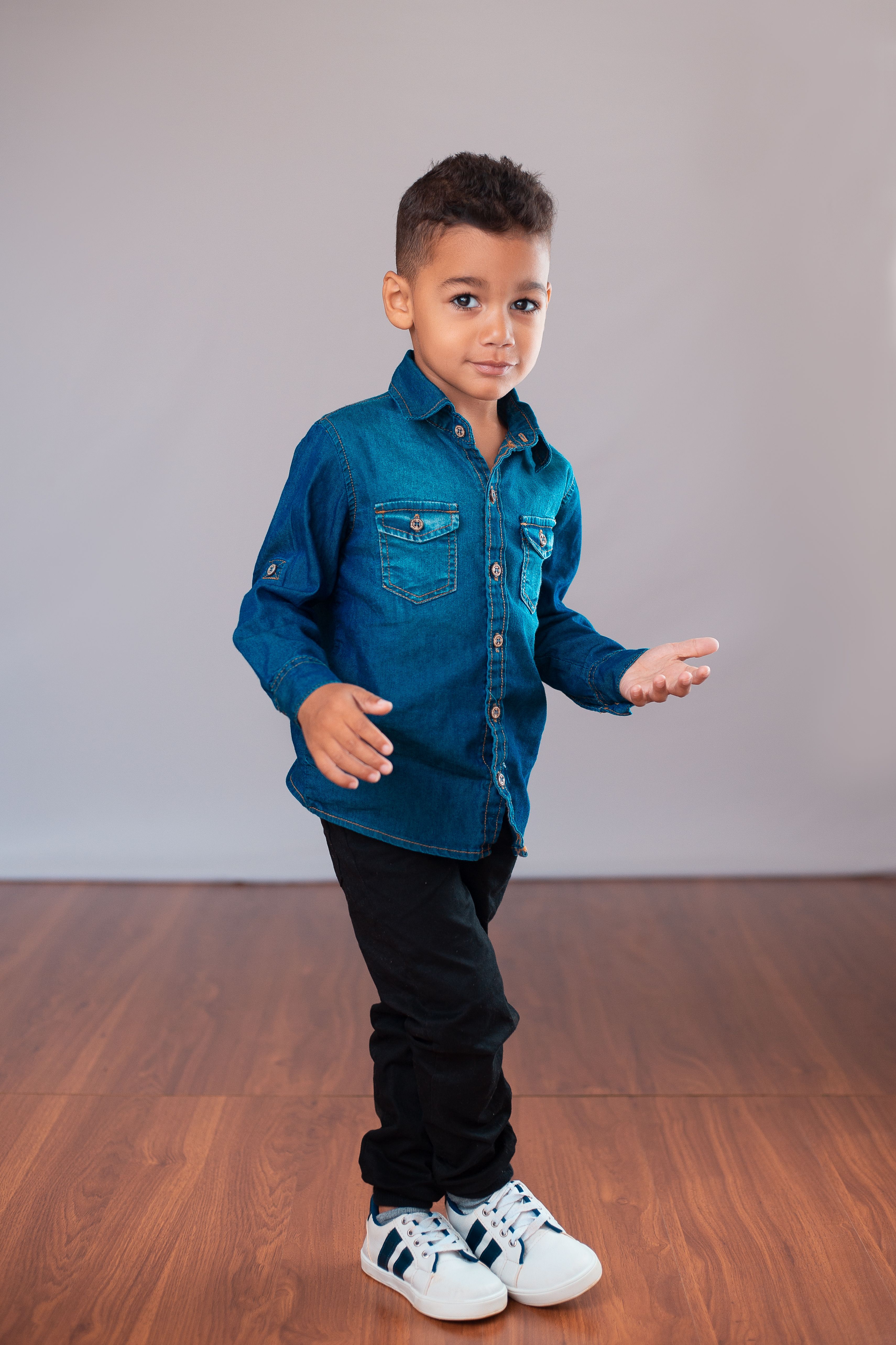 Boy in Blue Denim Longsleeves and Black Pants Standing on Brown Wooden ...