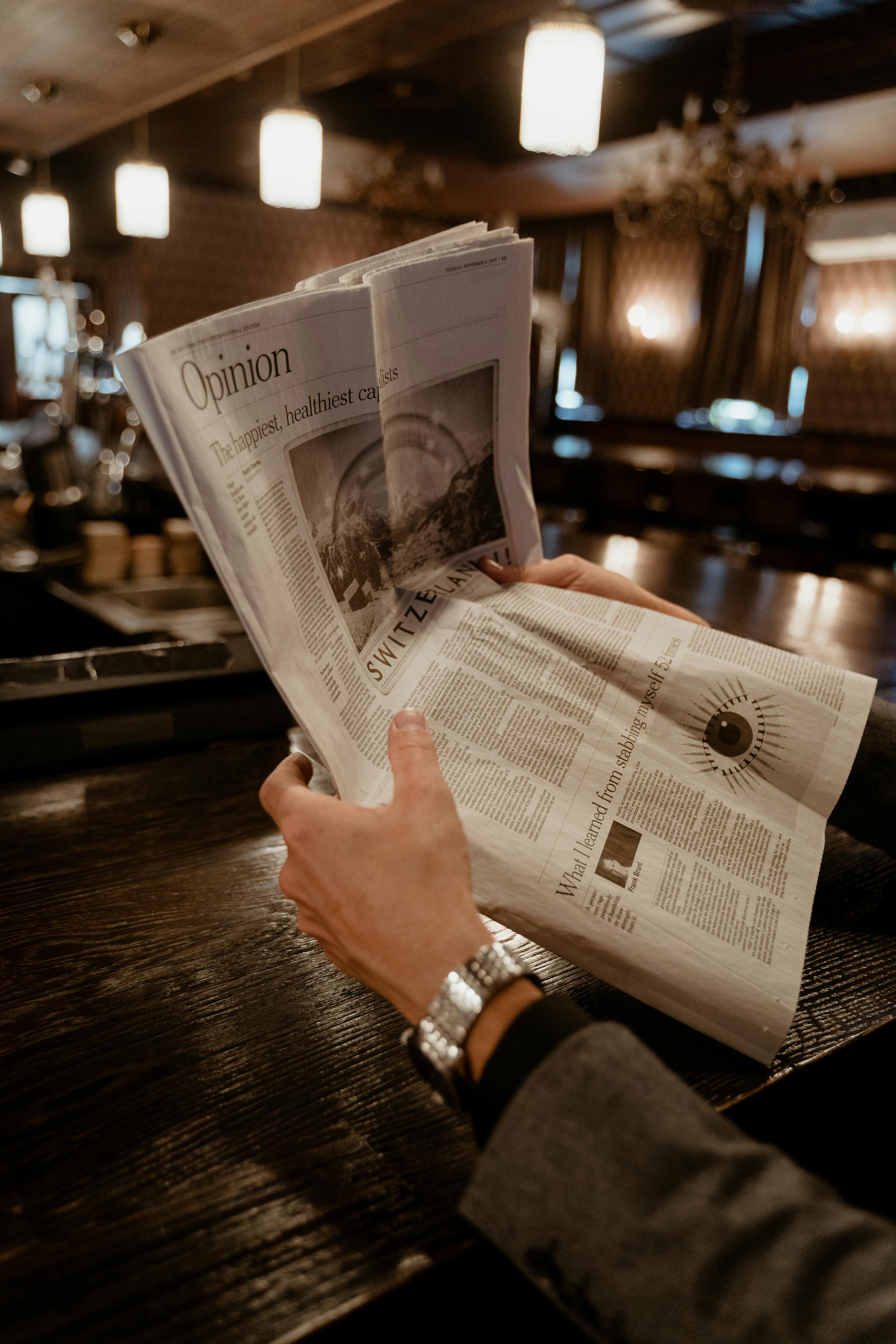 Close-Up Shot of a Person Holding Newspaper · Free Stock Photo