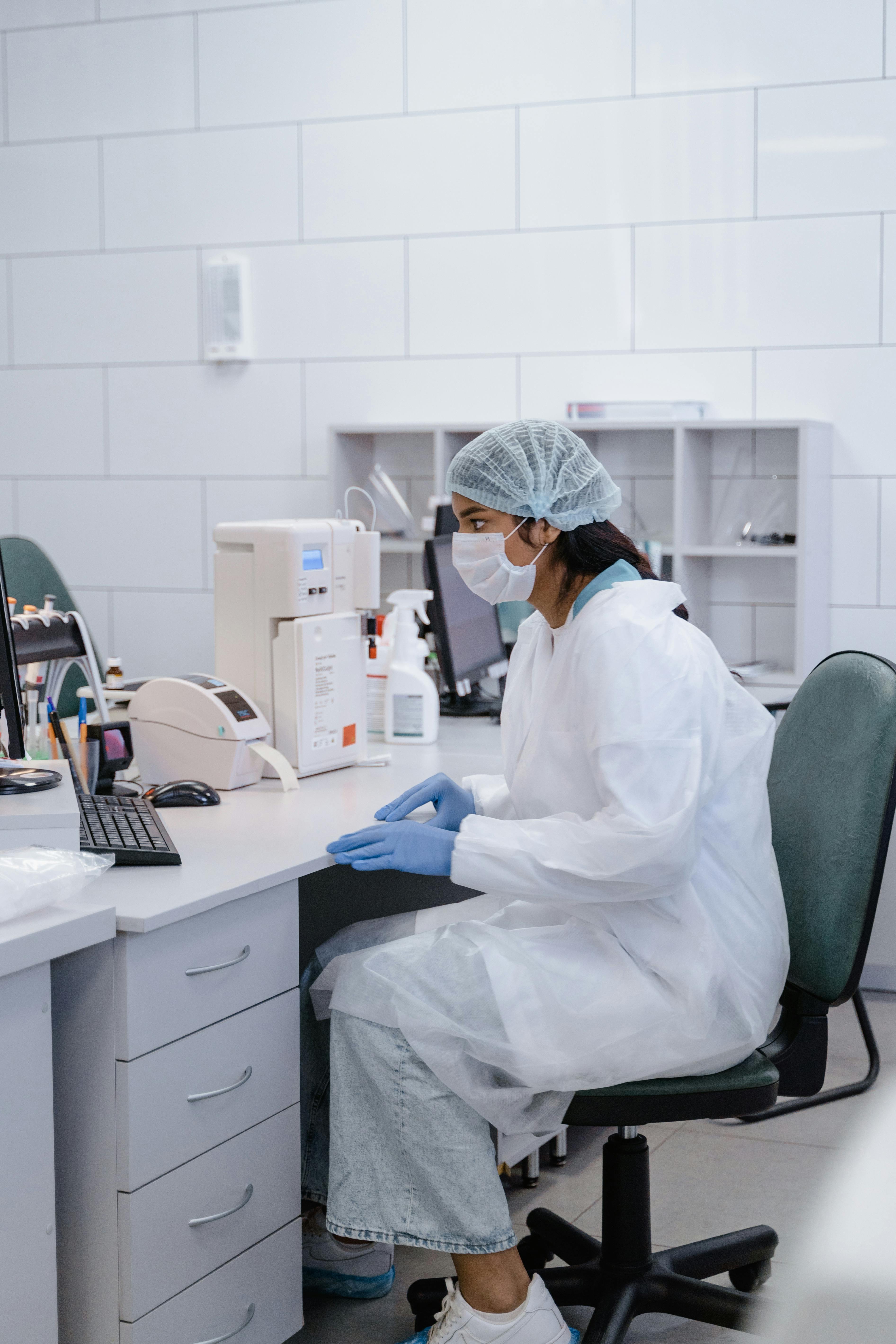 Scientist in a Lab Coat Working on a Computer · Free Stock Photo