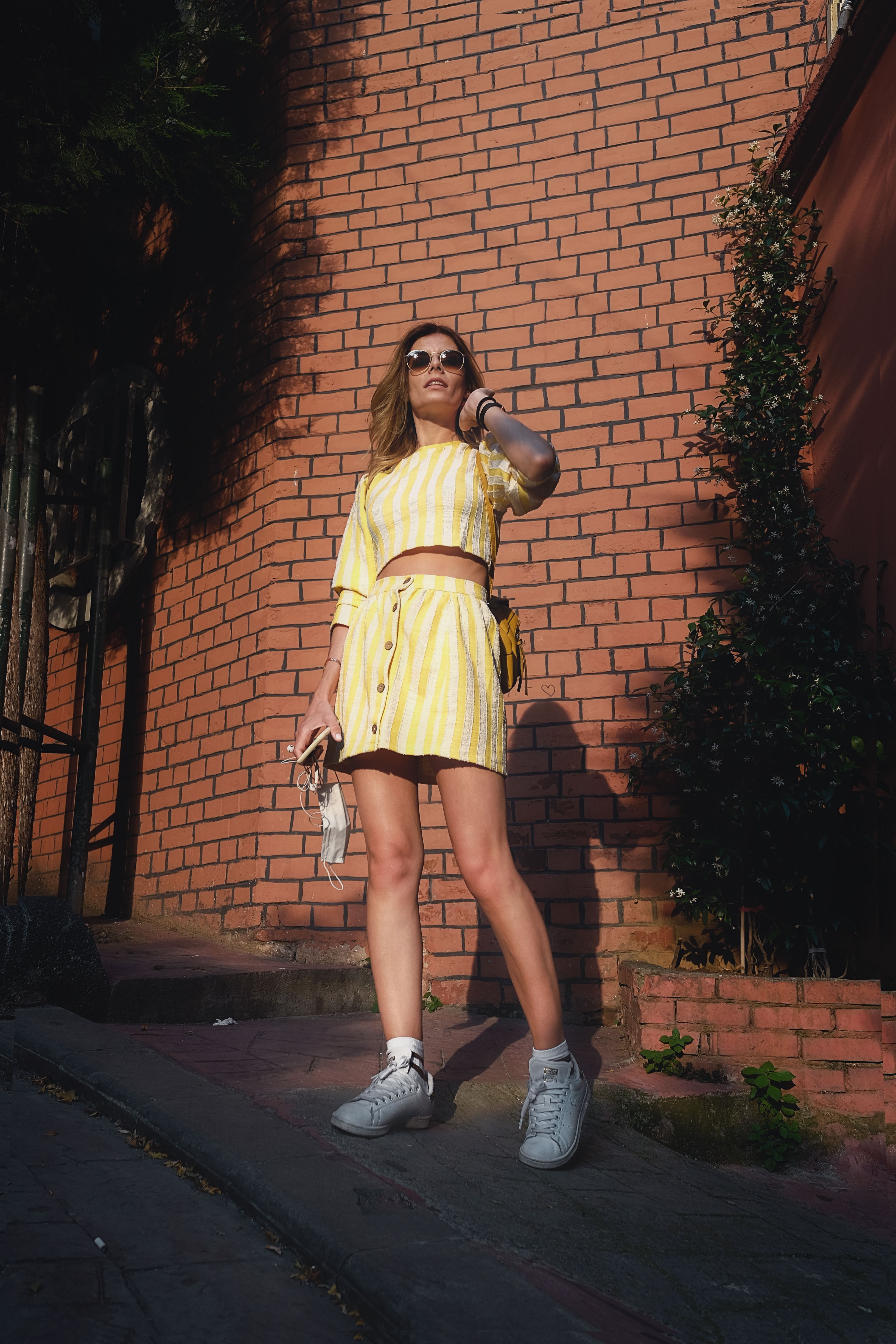 Mujer en rebeca rosa y camisa blanca apoyada en la pared · Foto de ...
