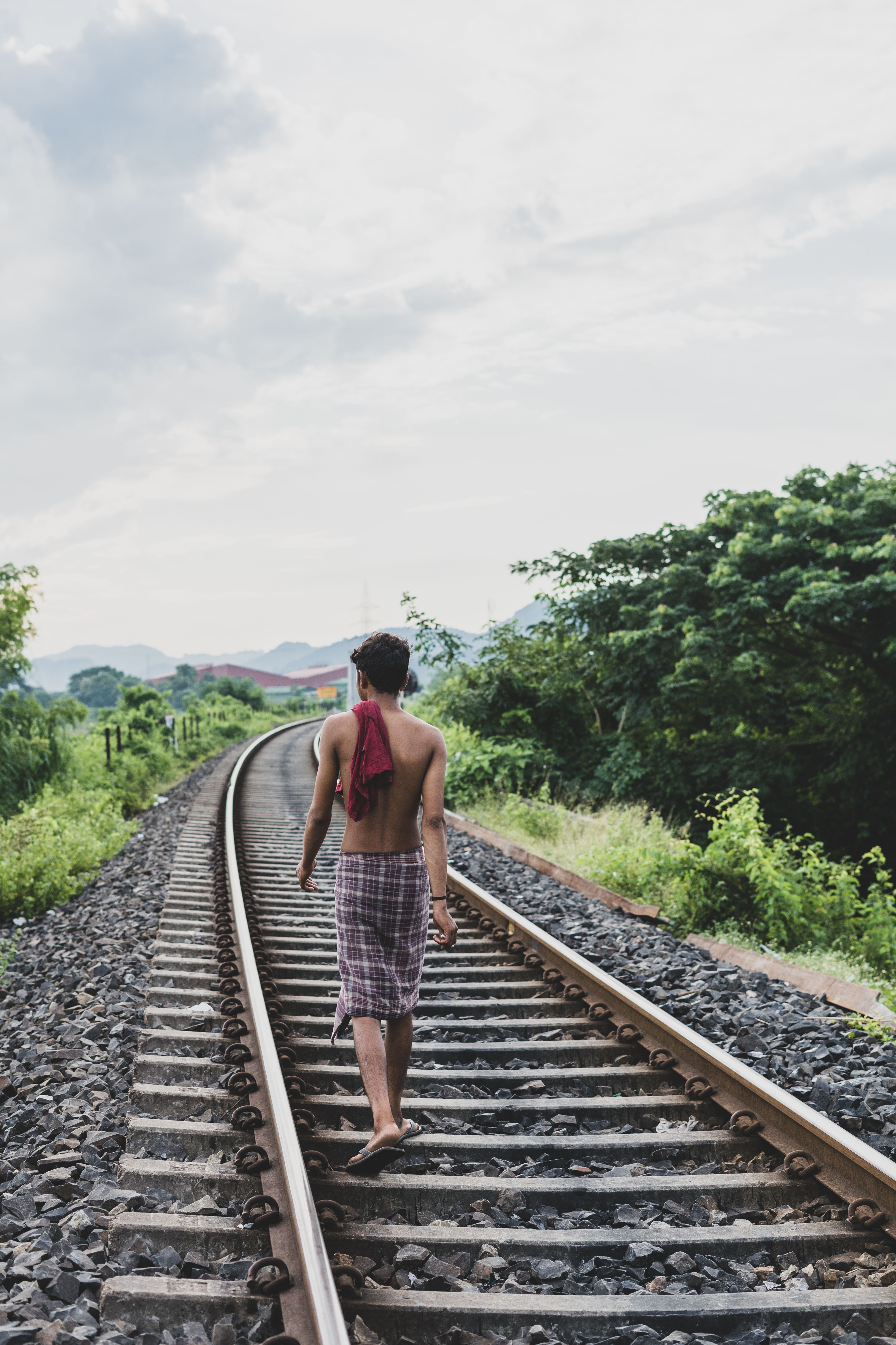A Man Walking on a Train Track · Free Stock Photo