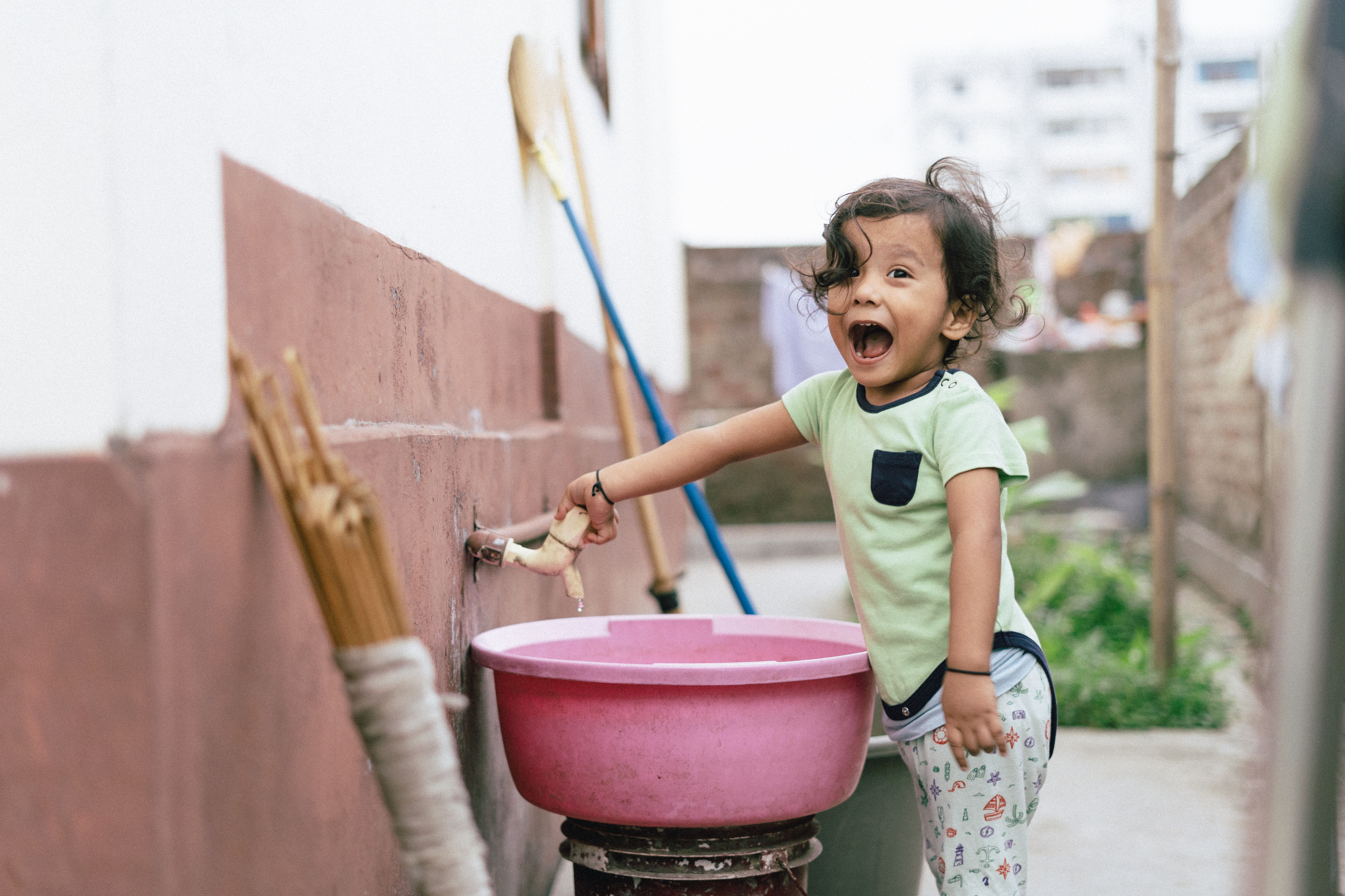 A Happy Little Kid Opening the Faucet · Free Stock Photo