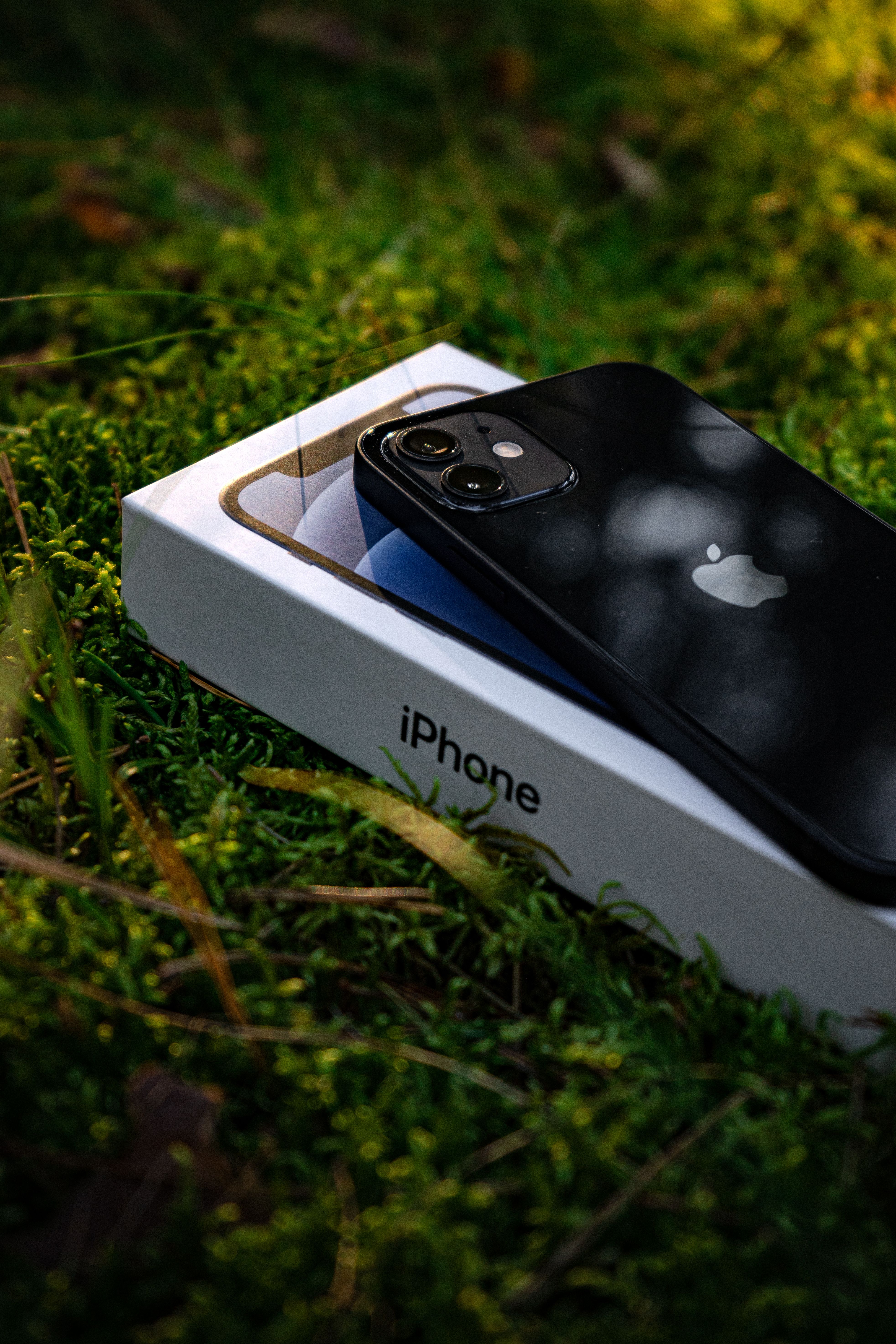 A Cellphone on Top of a Box on Green Grass Field in Close-up ...