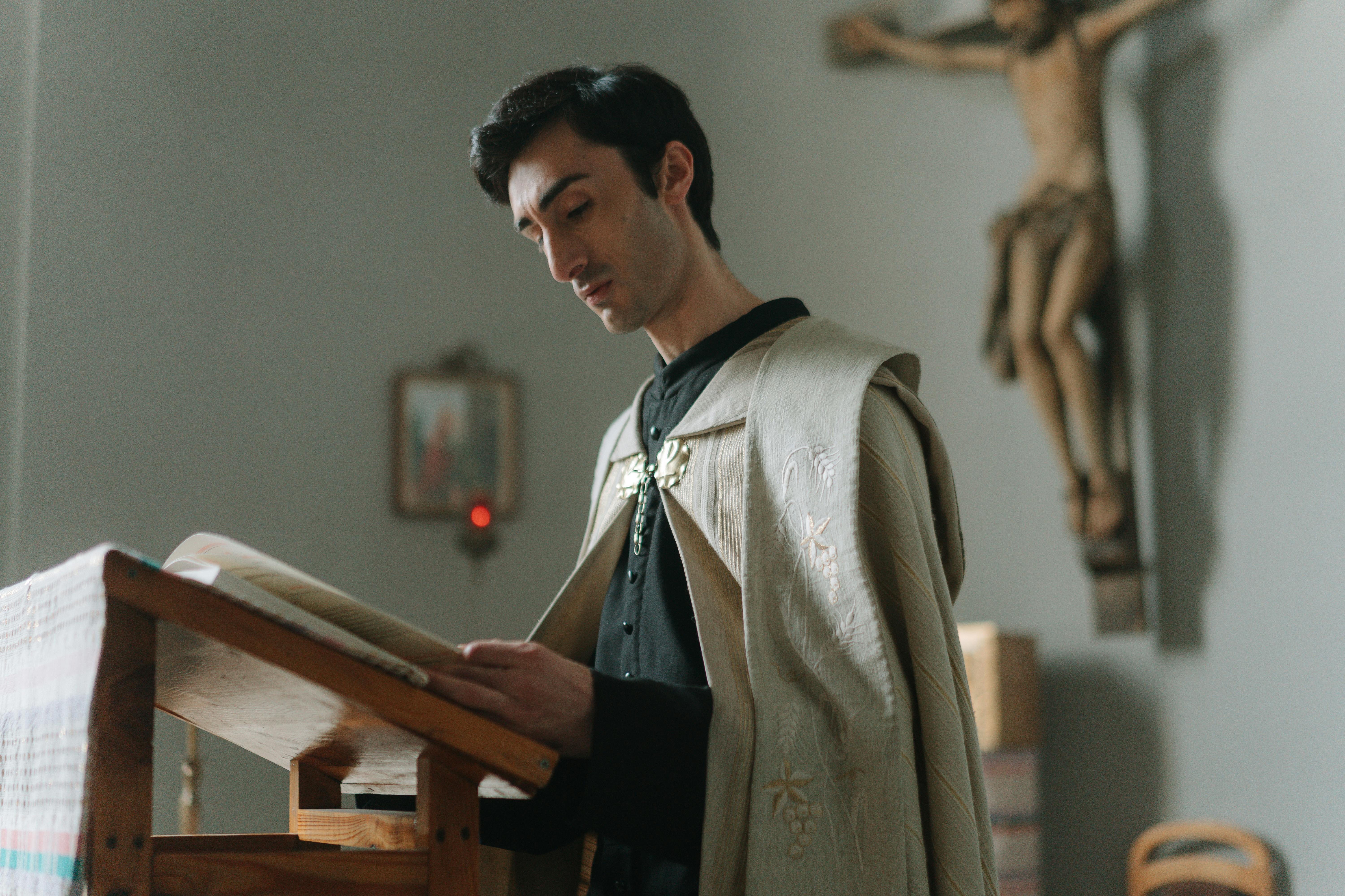A Priest Reading a Book on a Lectern · Free Stock Photo