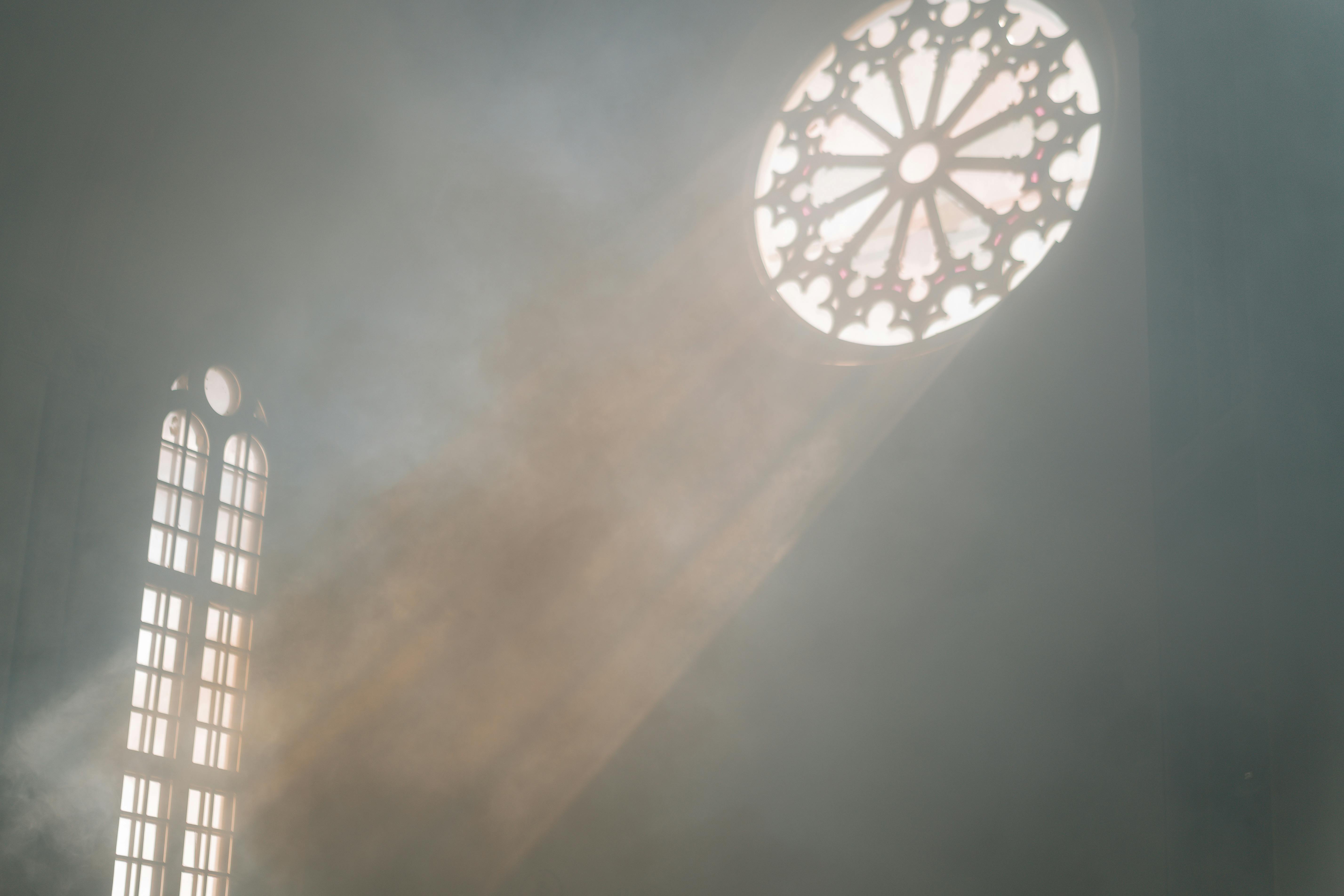 Sunrays Passing Through a Church Window Beside a Priest Holding a Bible ... Sunrays Passing Through a Church Window Beside a Priest Holding a Bible ...