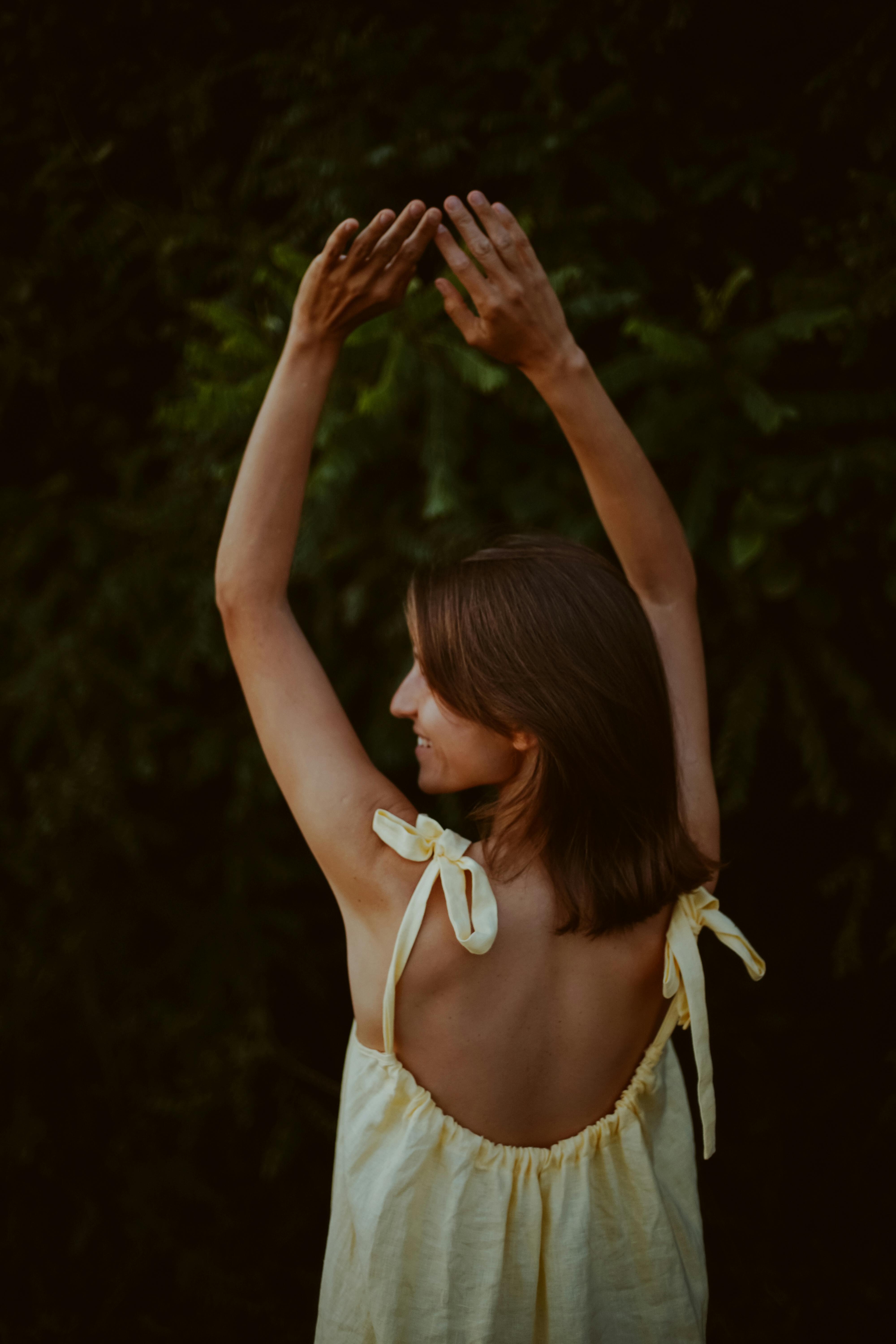 Back View Of a Woman Raising Her Hands · Free Stock Photo