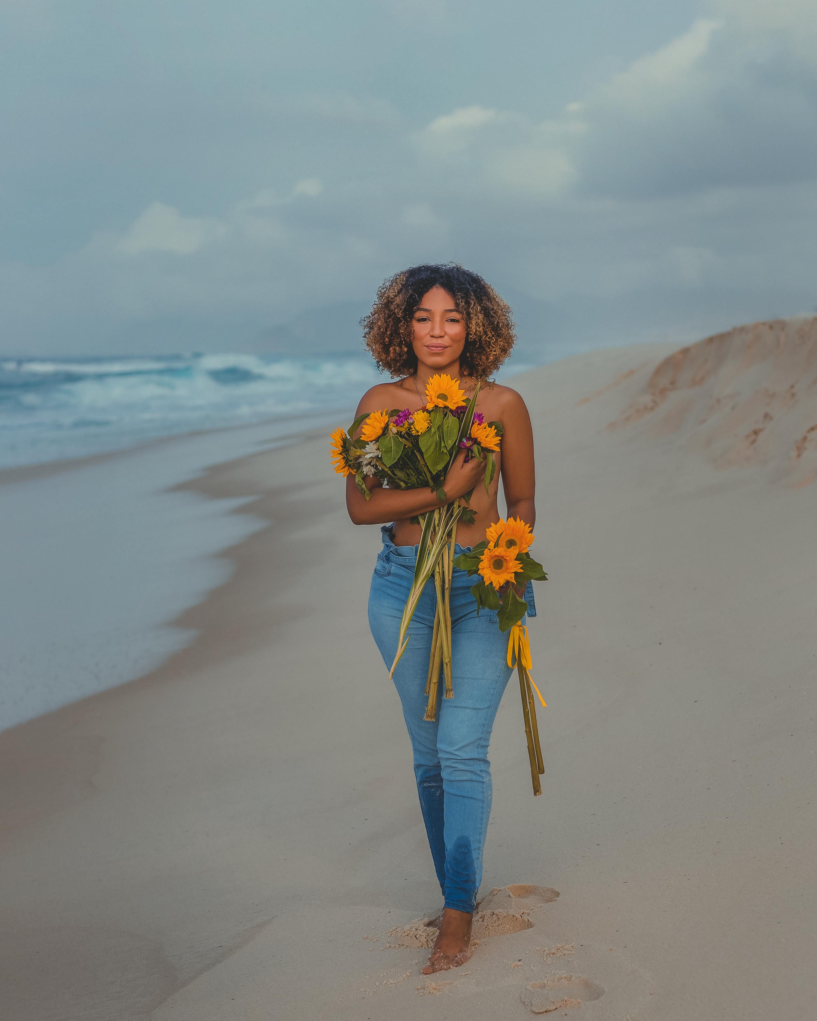 Woman Standing on a Beach with Flowers · Free Stock Photo