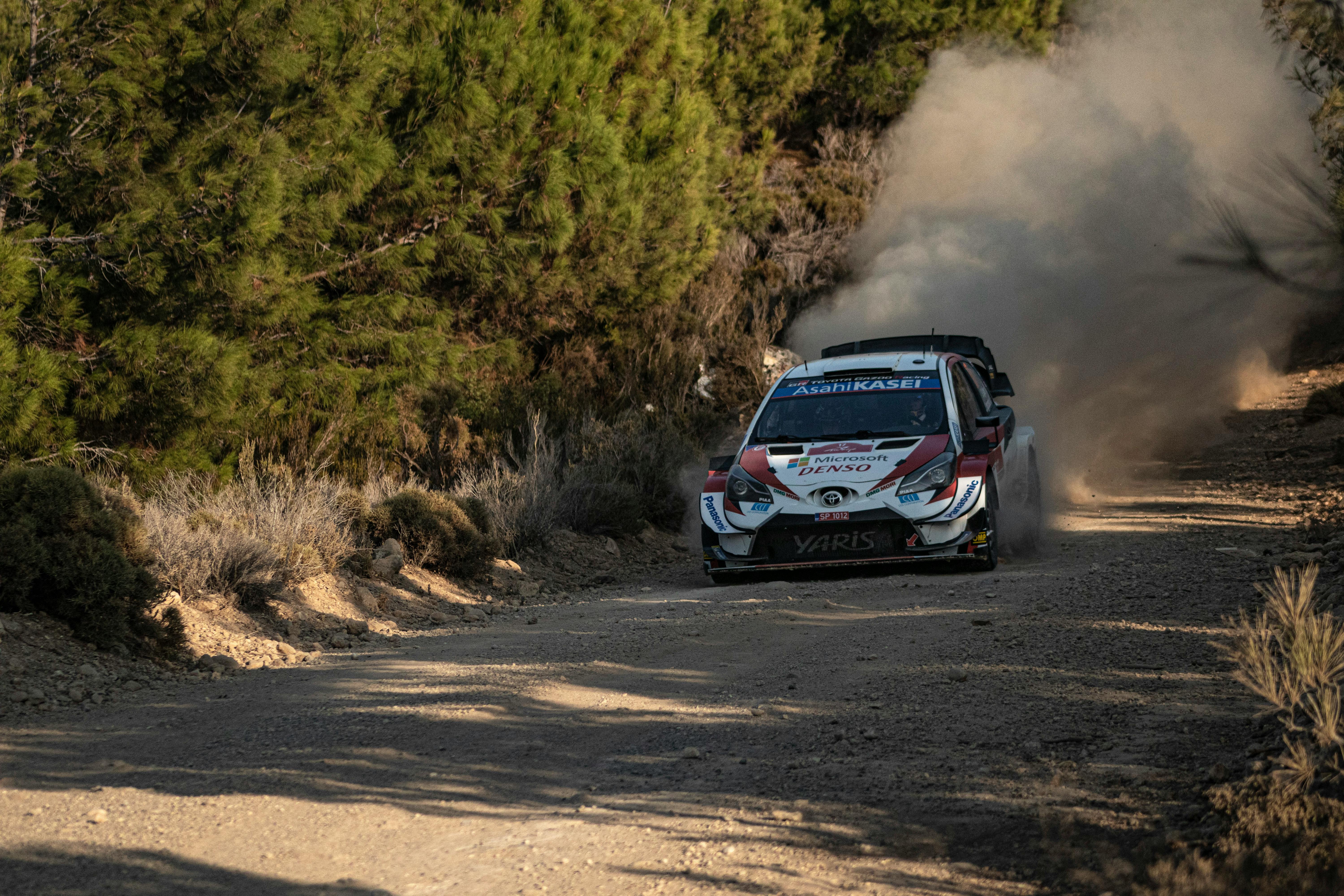 A White Race Car on Dirt Road Emitting Dust · Free Stock Photo