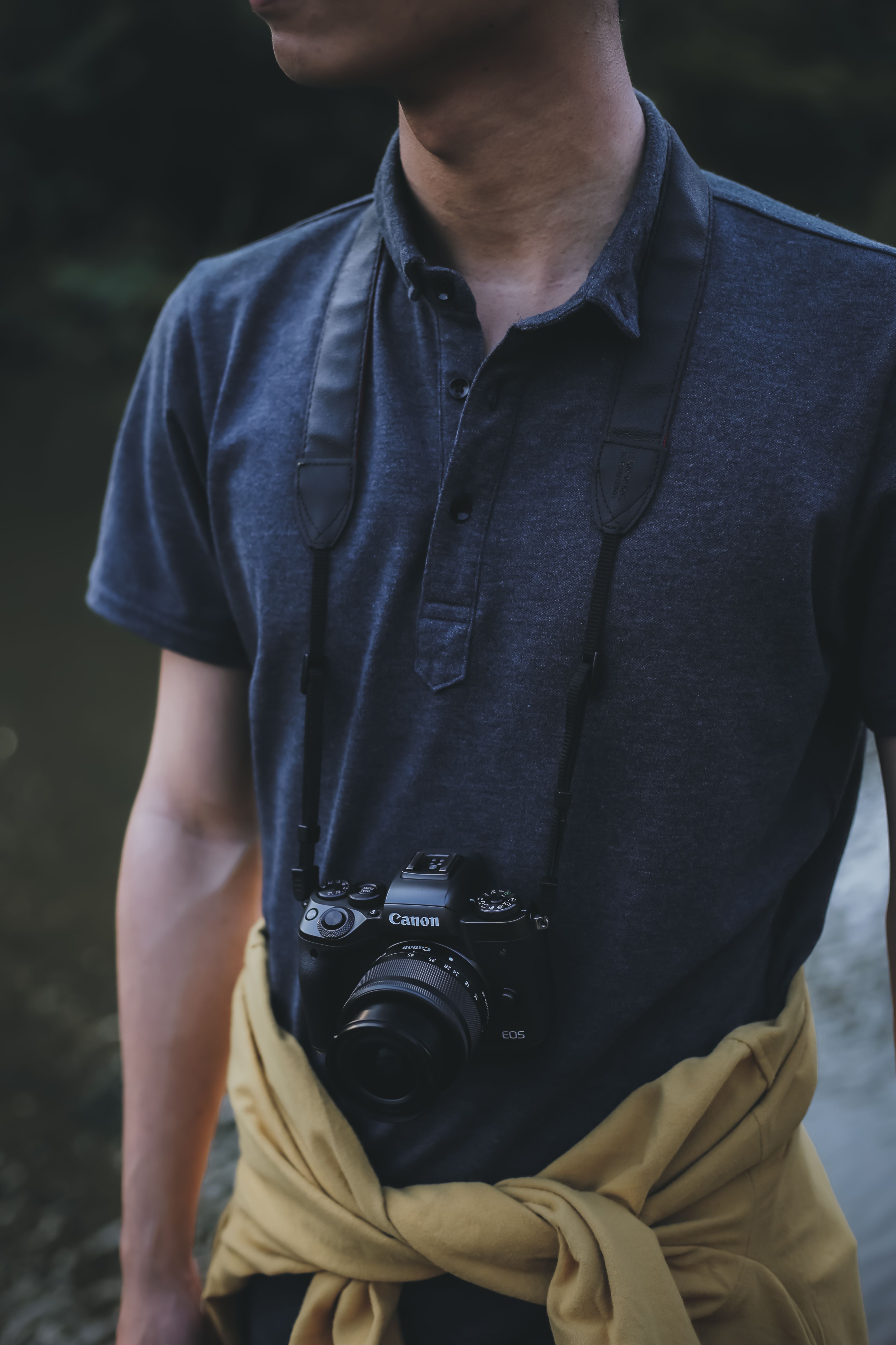 Man in Blue Polo Shirt Standing with a Black Dslr Camera · Free Stock Photo