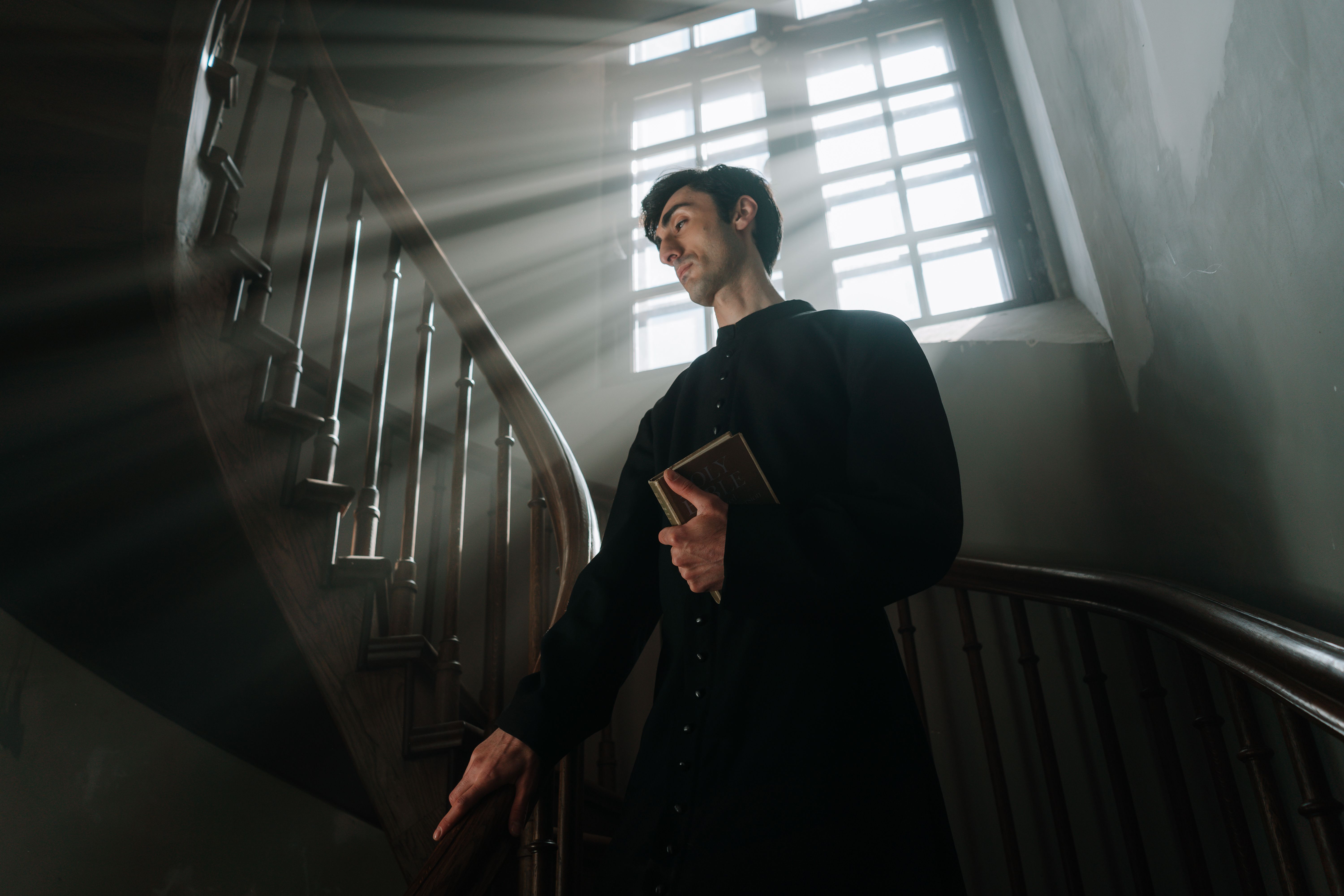 A Low Angle Shot of a Priest Reading Bible · Free Stock Photo
