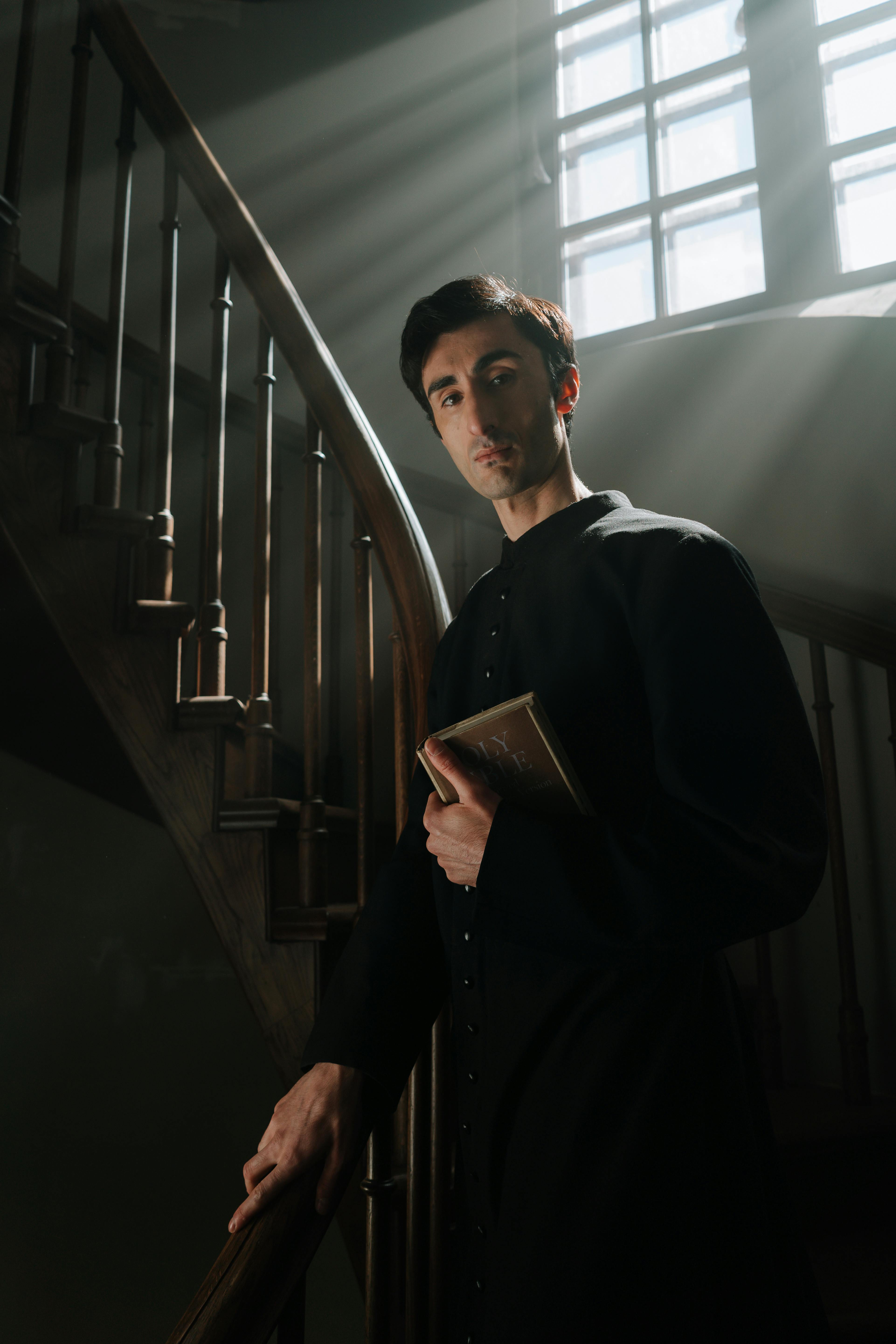 Photo of a Priest Holding a Bible · Free Stock Photo