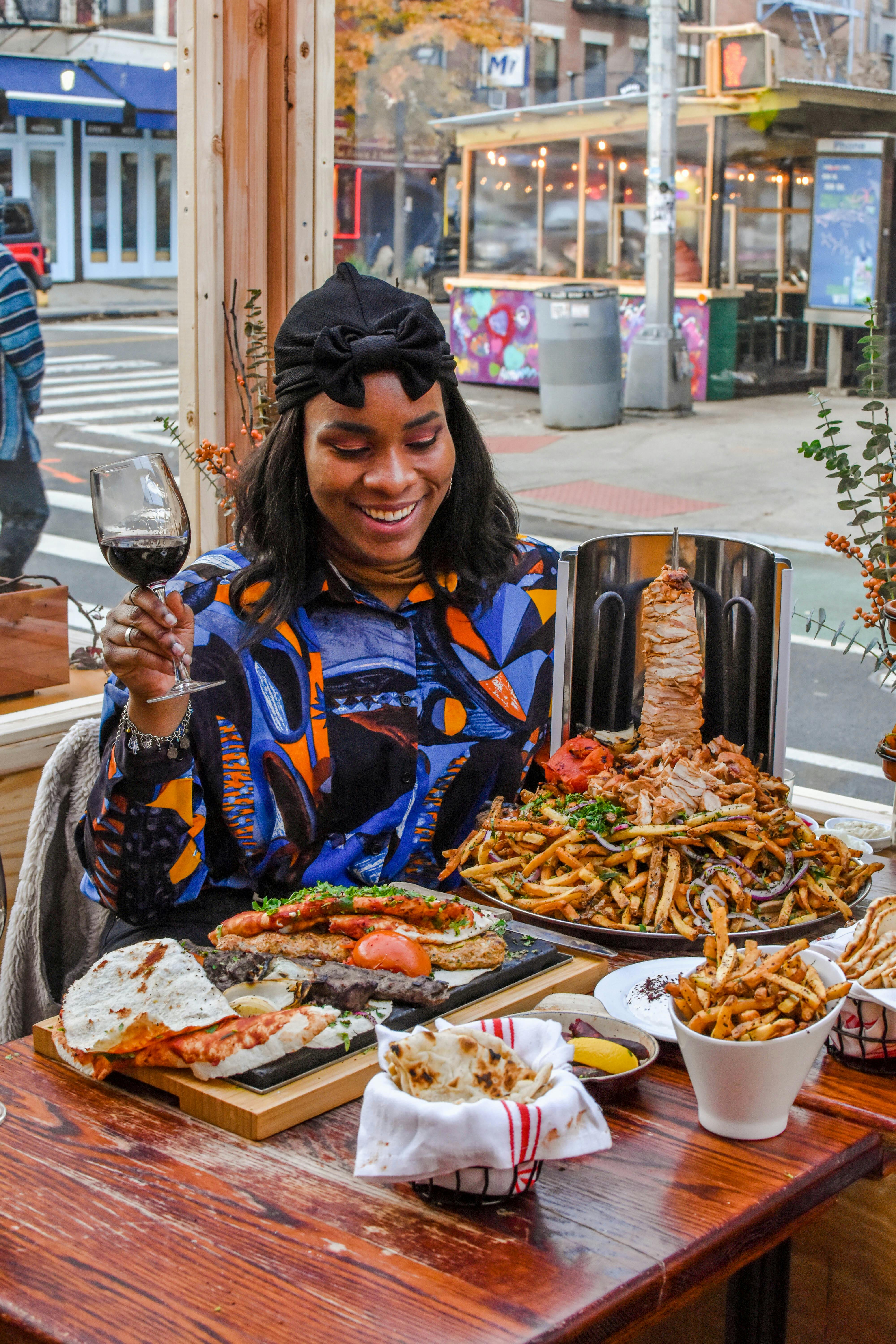 Woman Sitting at Outdoor Restaurant Table with Food · Free Stock Photo