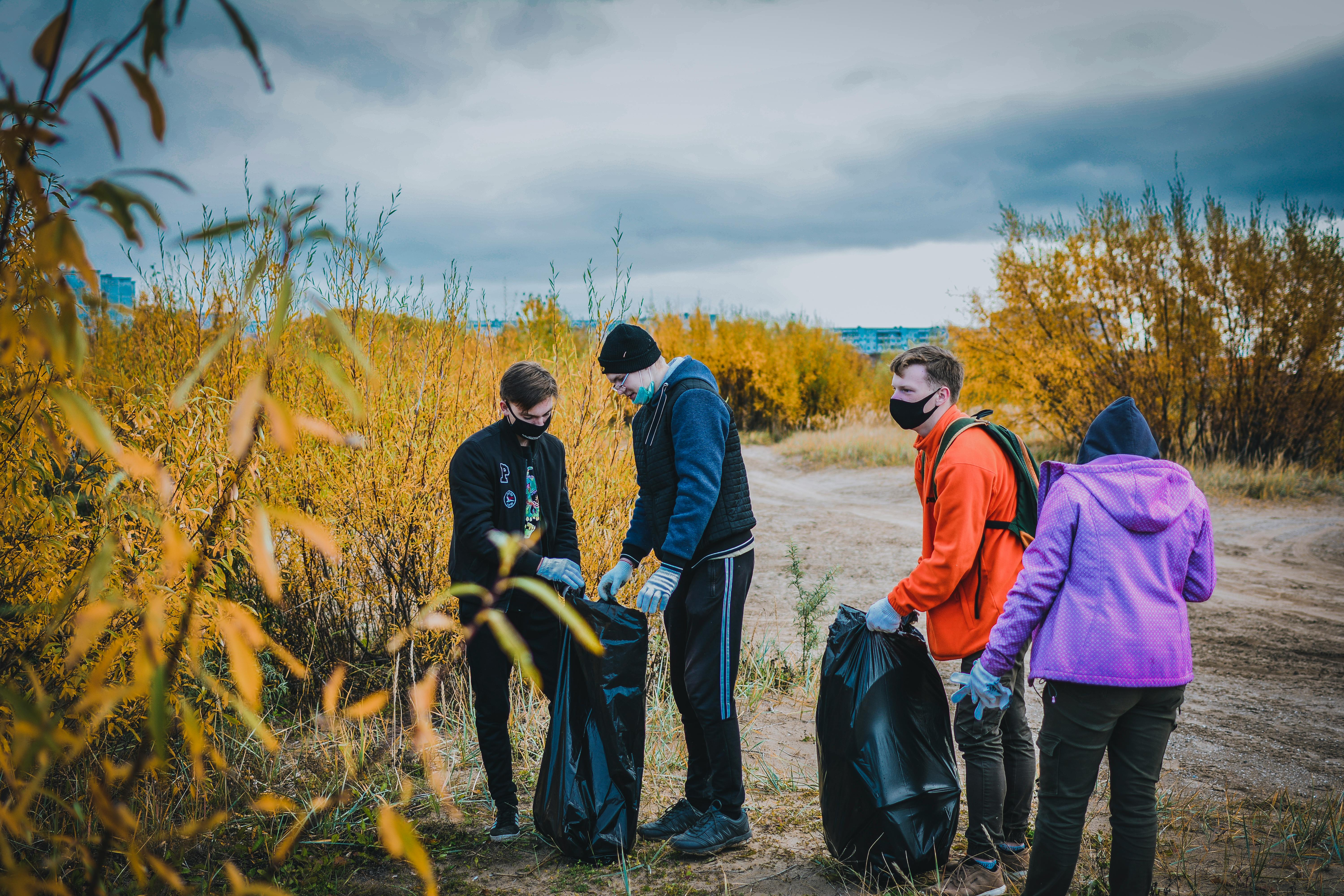 Four People Collecting Garbage · Free Stock Photo