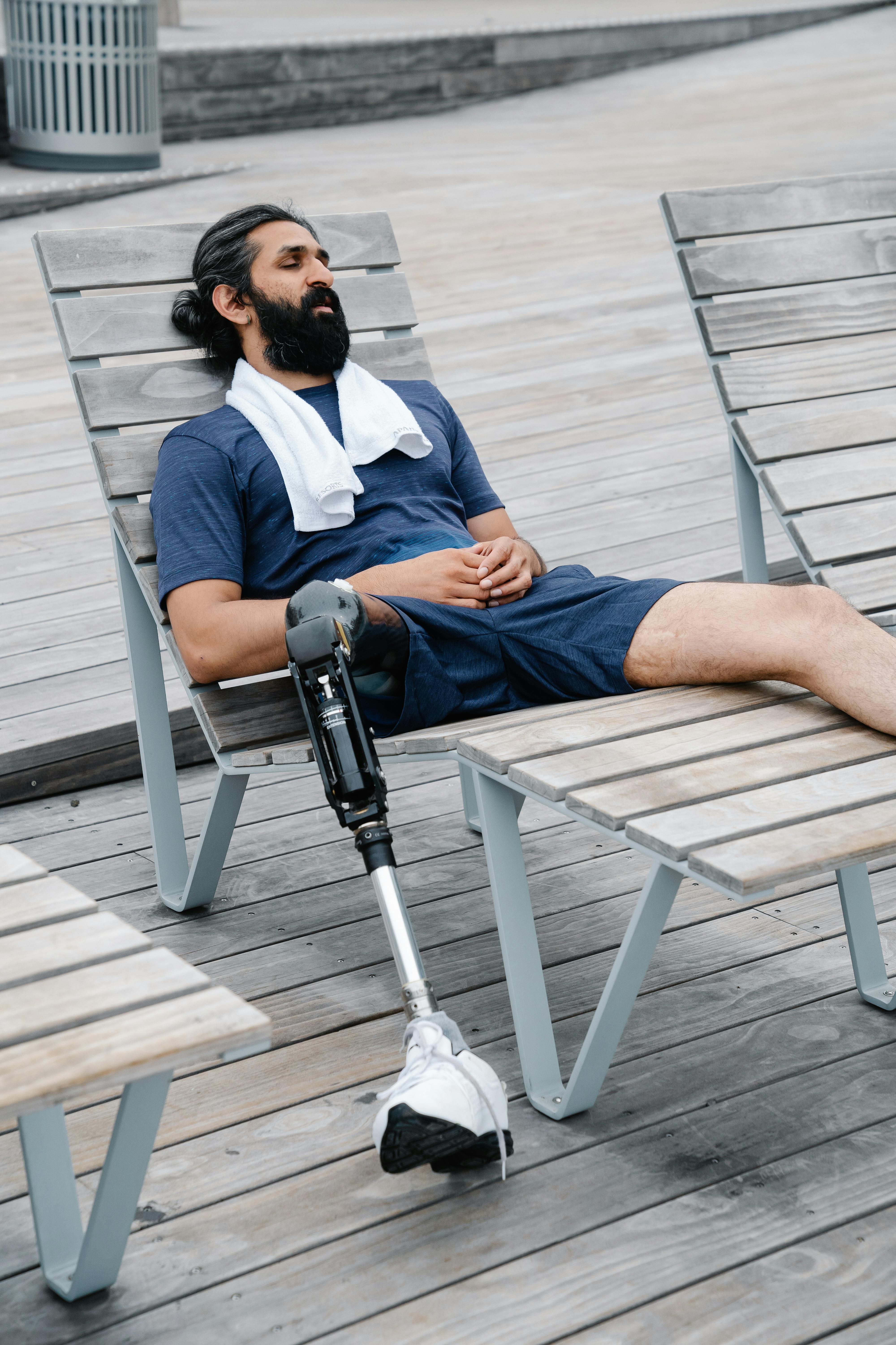 Man with Prosthetic Leg resting on Lounge Chairs · Free Stock Photo