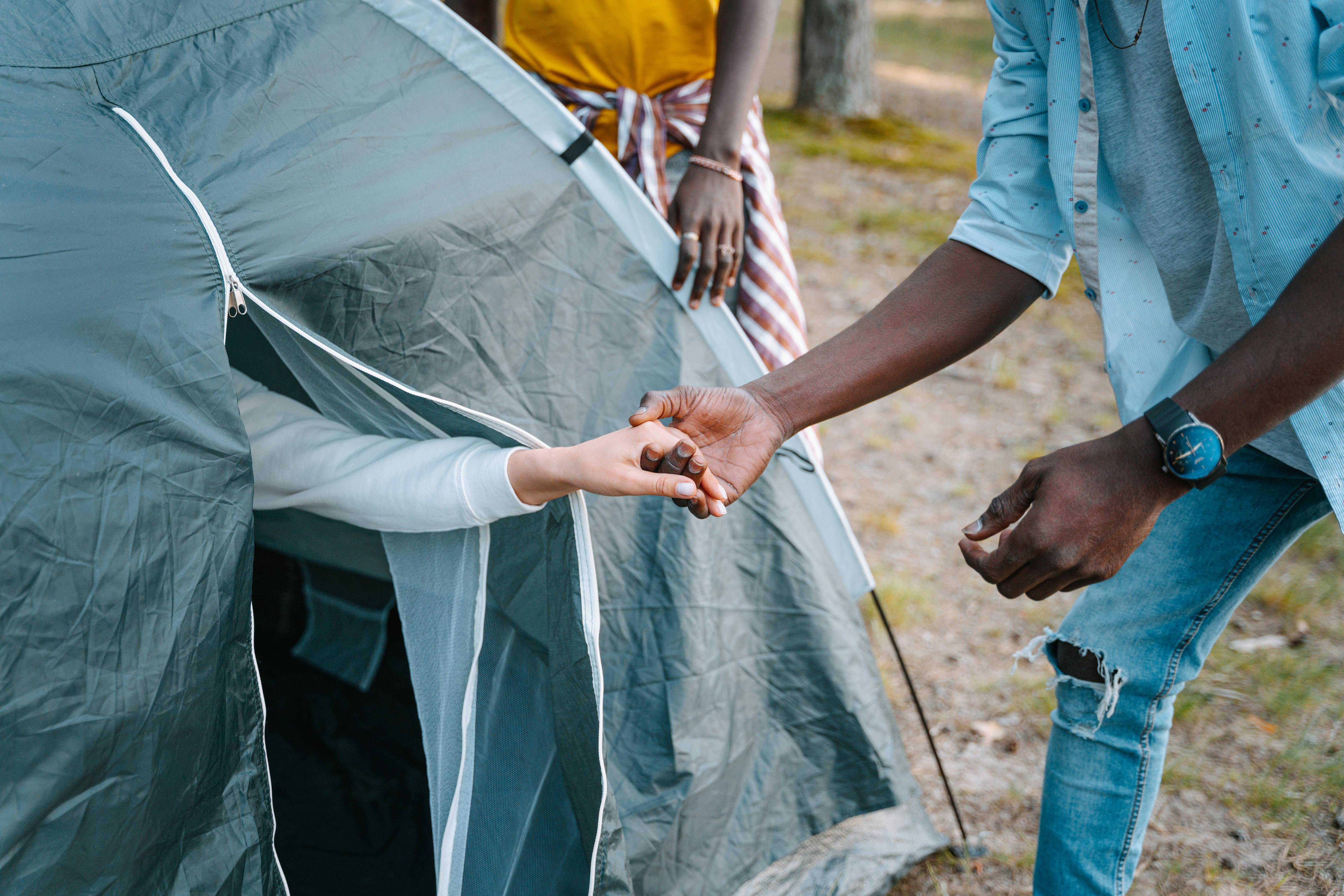 Person Holding a Hand While Inside the Tent · Free Stock Photo