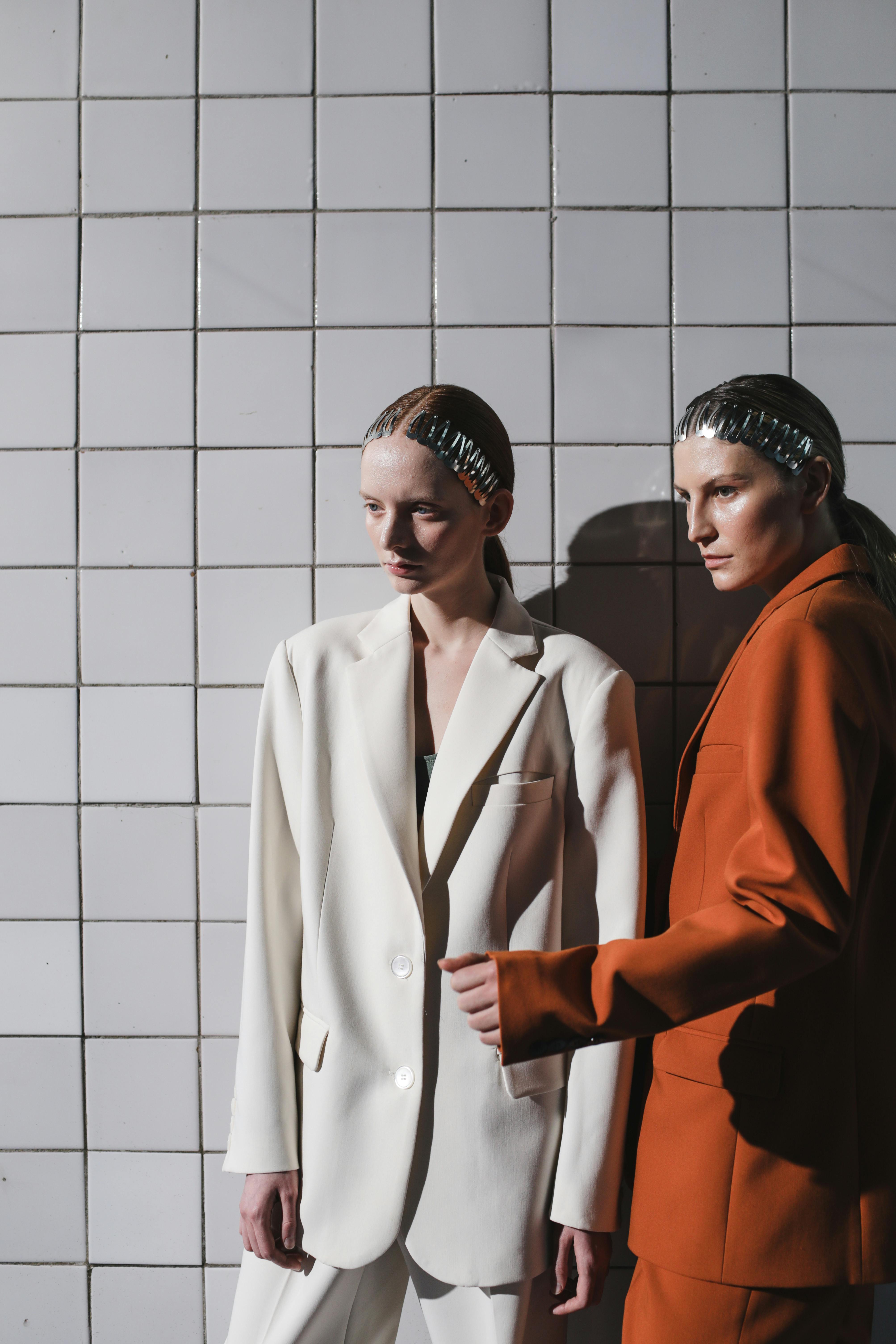 Beautiful Models in Elegant Jackets Posing by Wall · Free Stock Photo