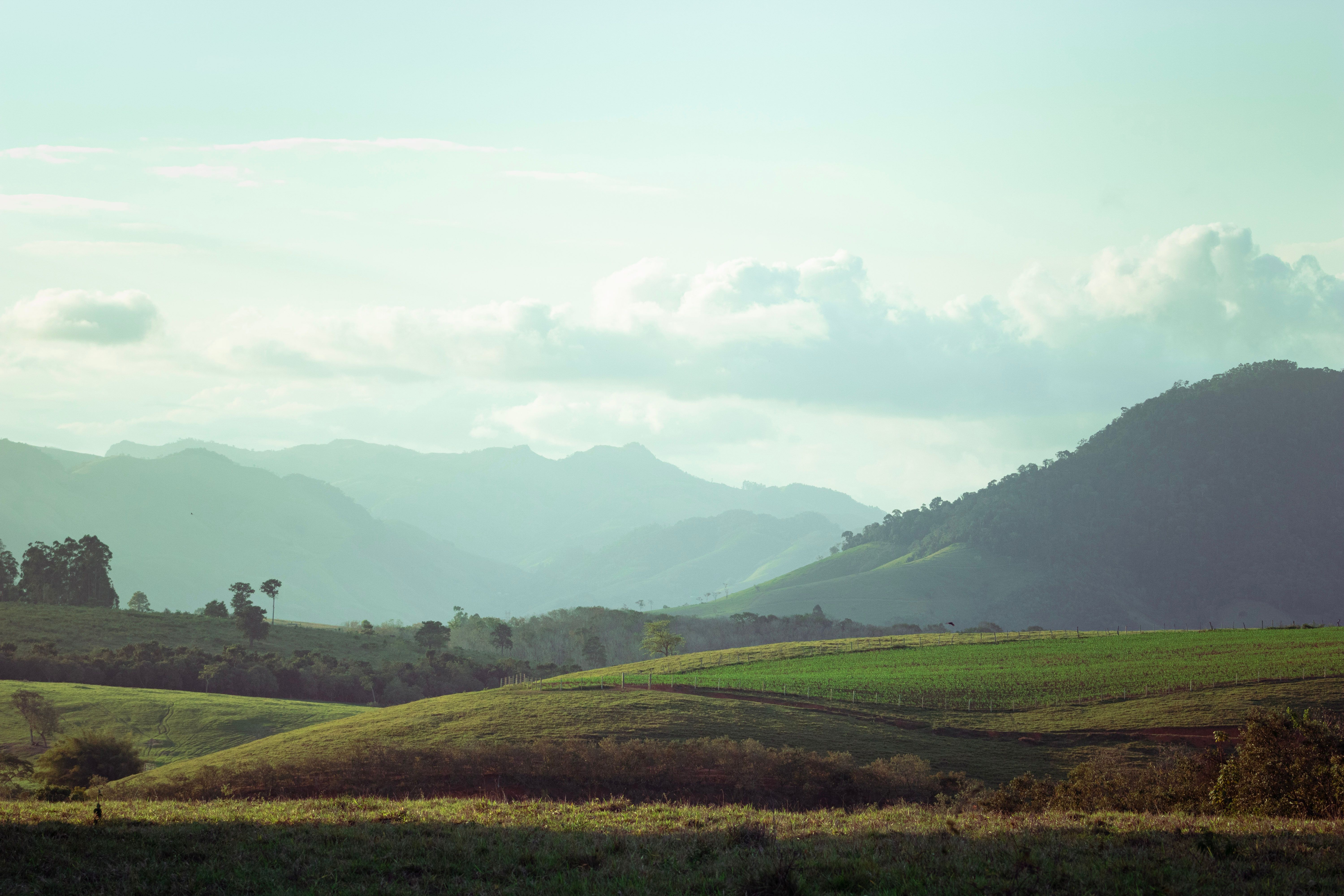 A Grass Field near the Mountain · Free Stock Photo