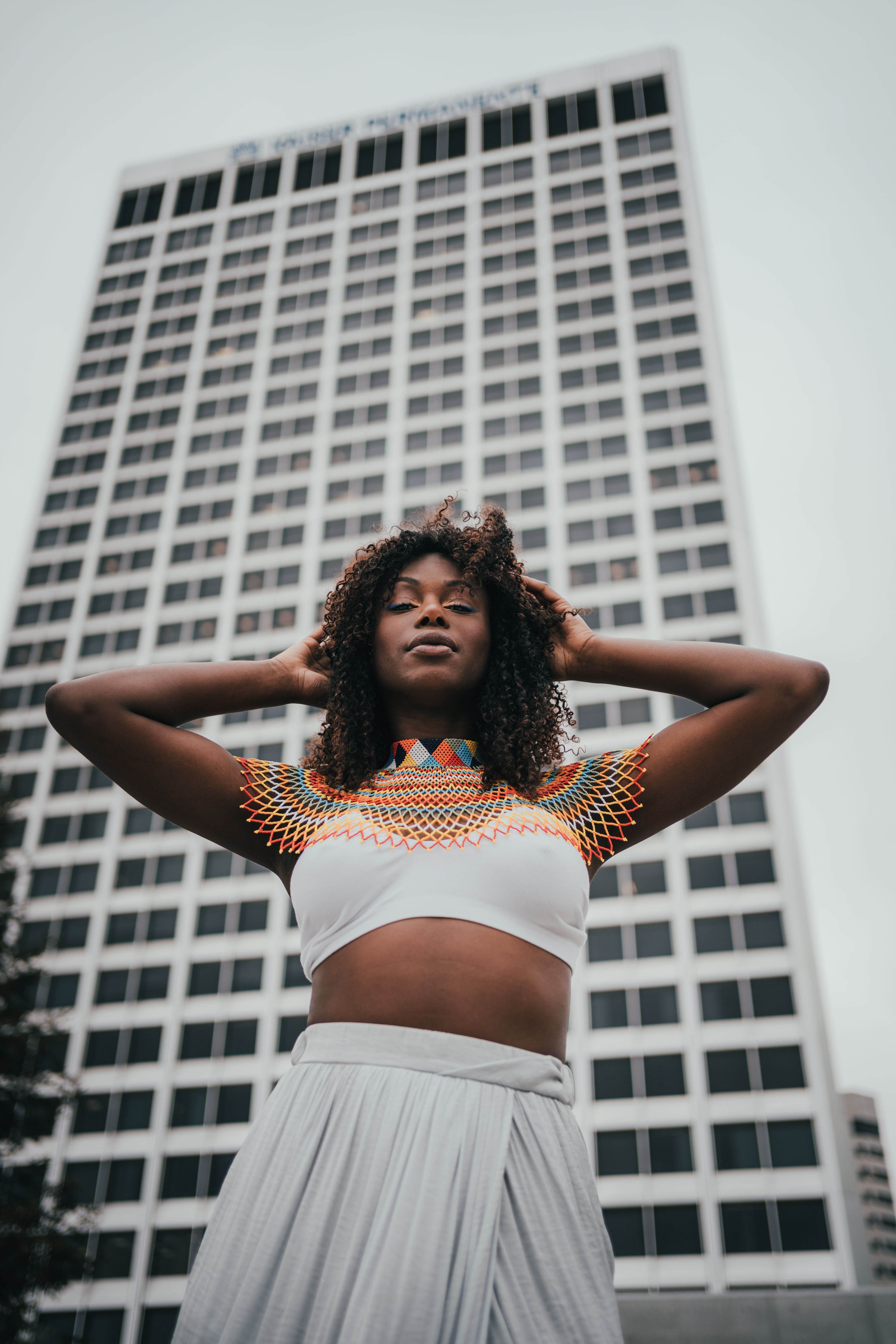 Young African-American woman standing in front of skyscraper · Free ...