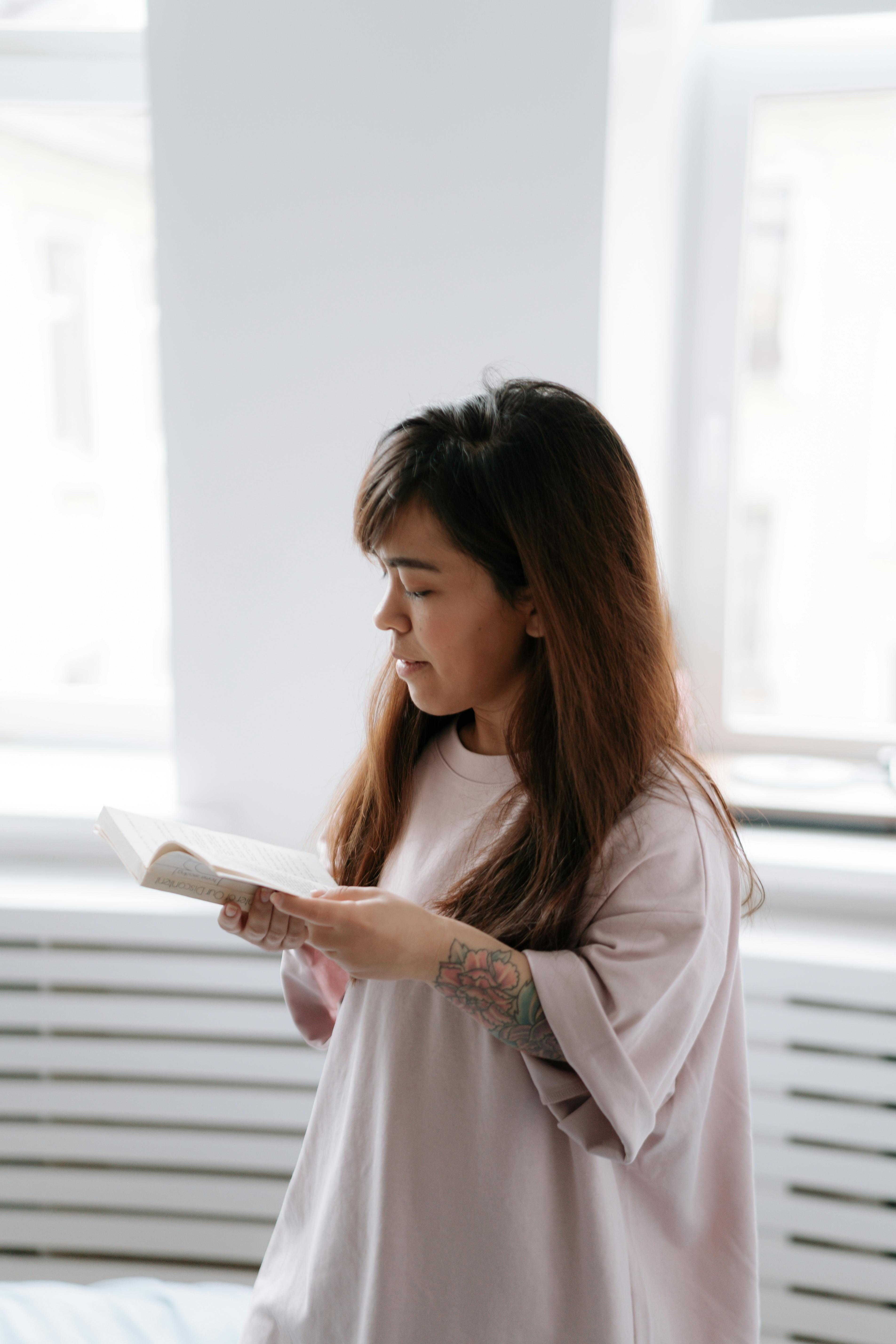 Dwarf woman standing and reading book · Free Stock Photo