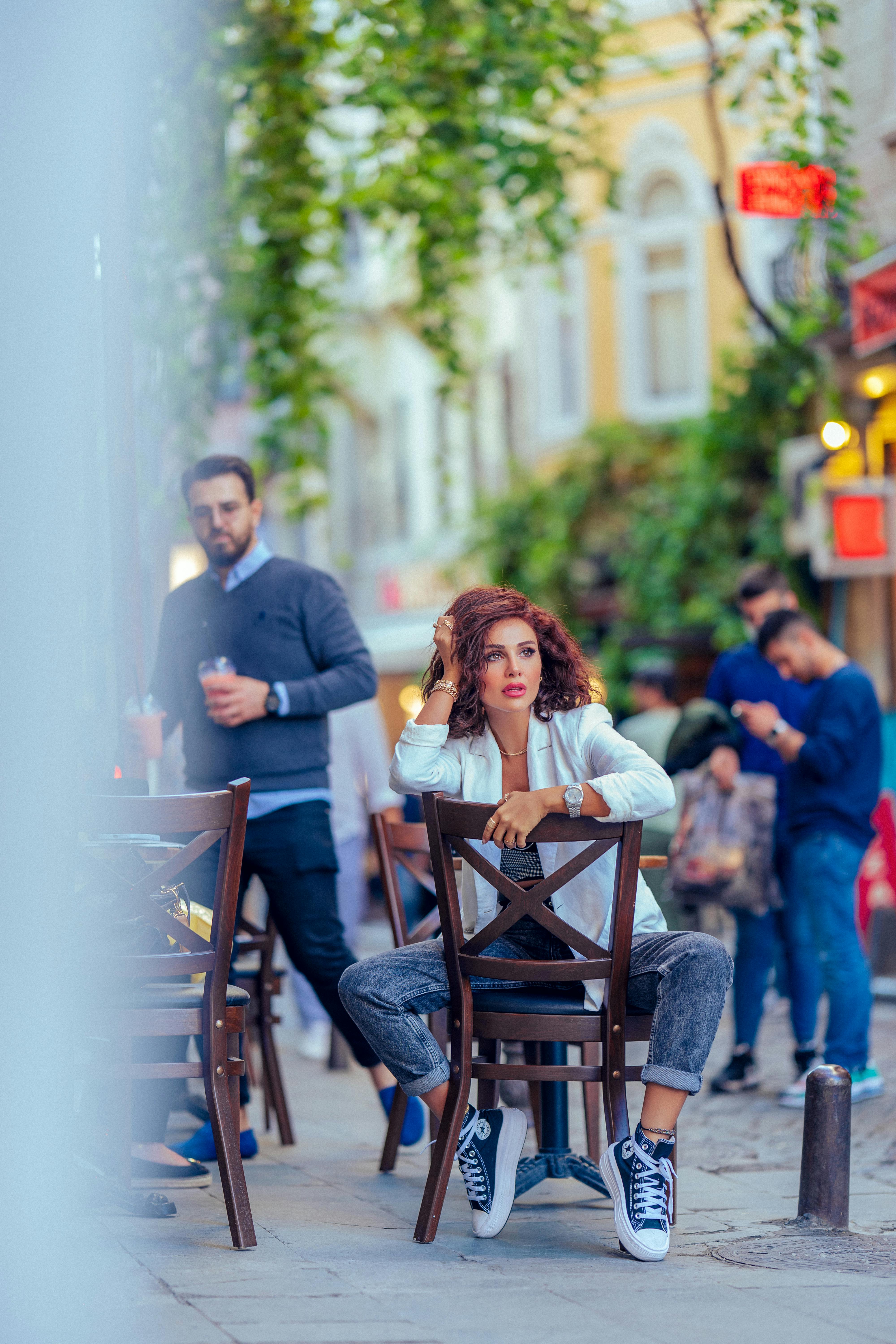 Woman Sitting Backwards on a Chair on the Street · Free Stock Photo