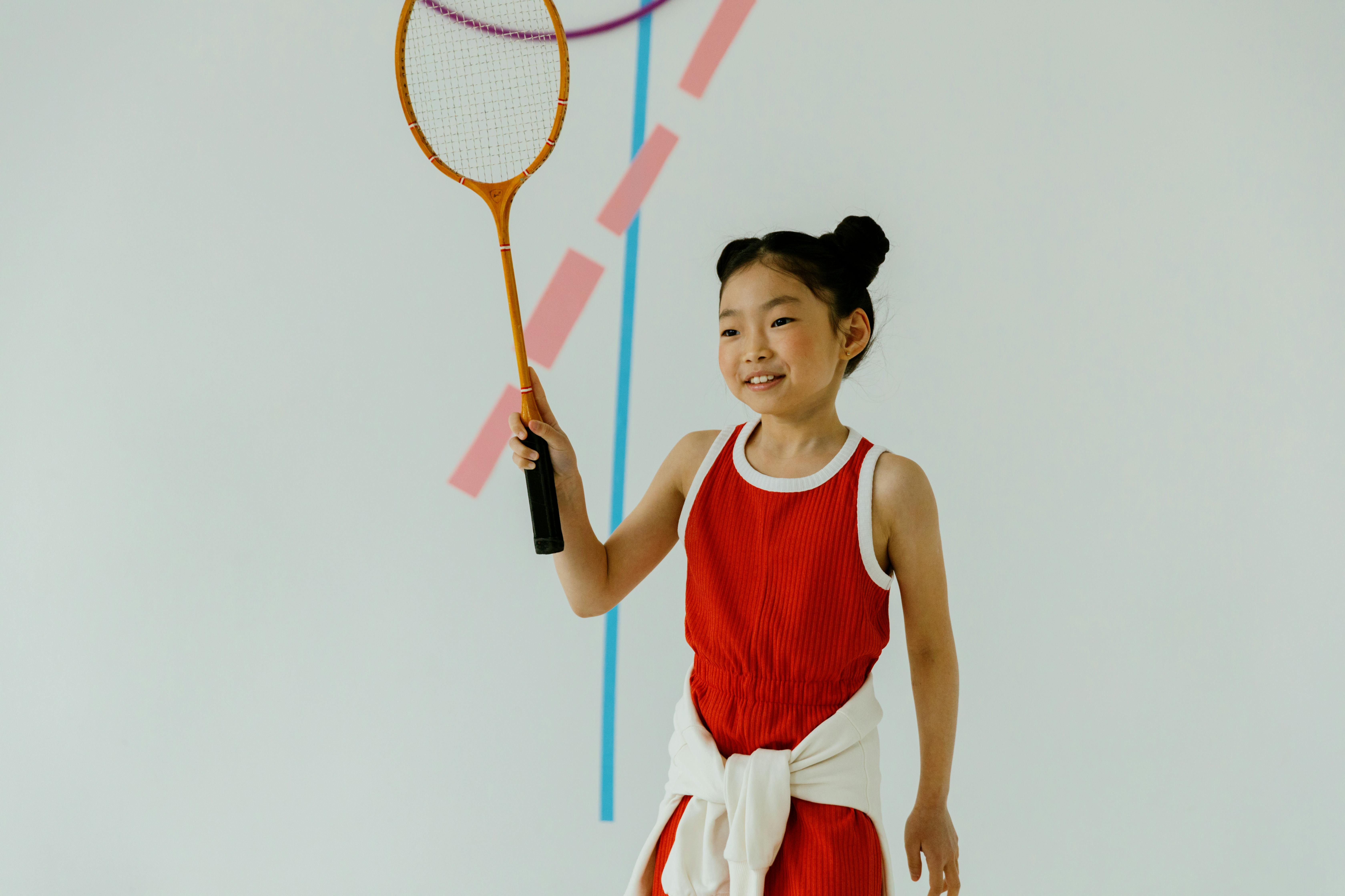 Girl in Red Sleeveless Top Holding an Orange Tennis Racket · Free Stock ...