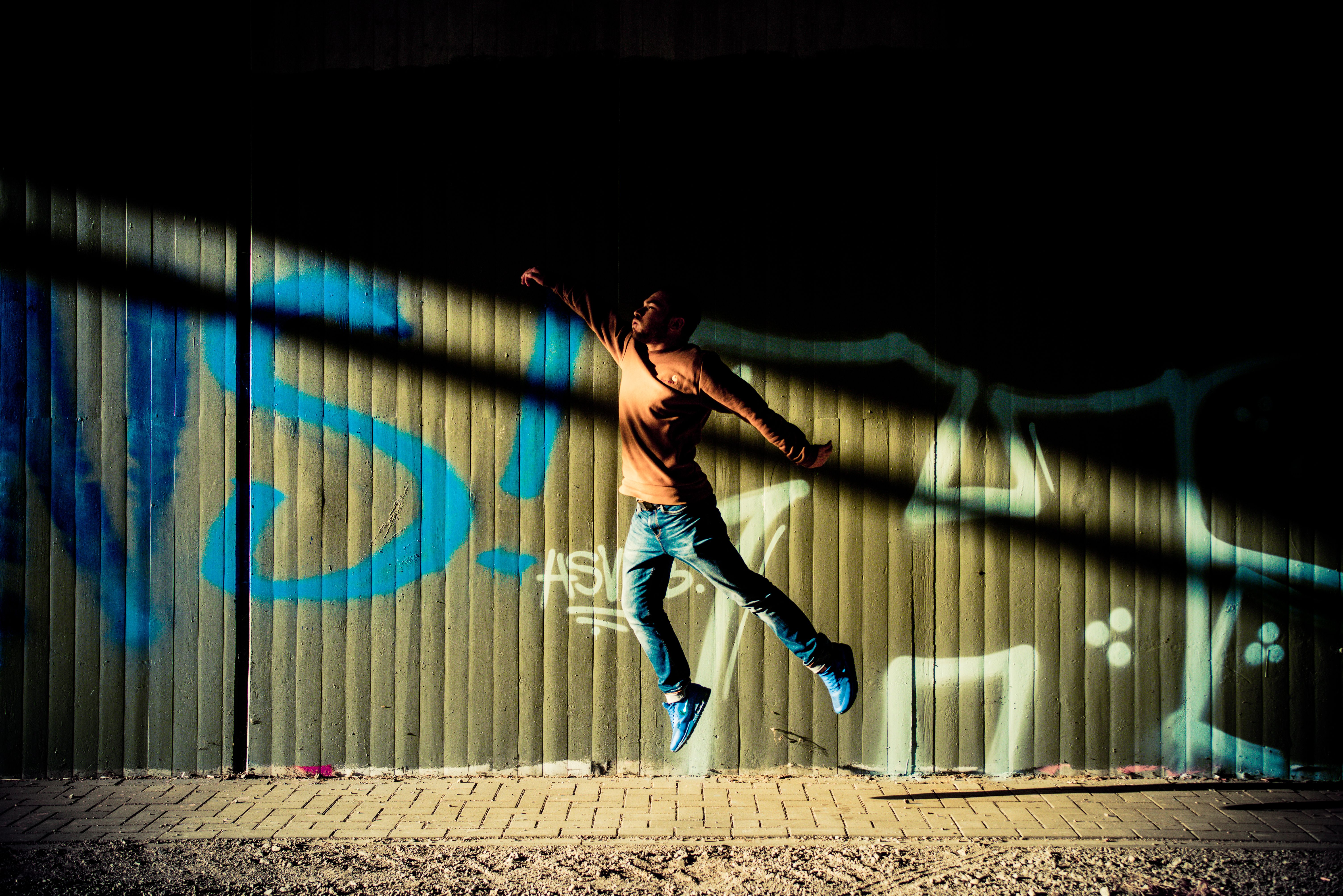 Man with face obscured by shadow jumping · Free Stock Photo