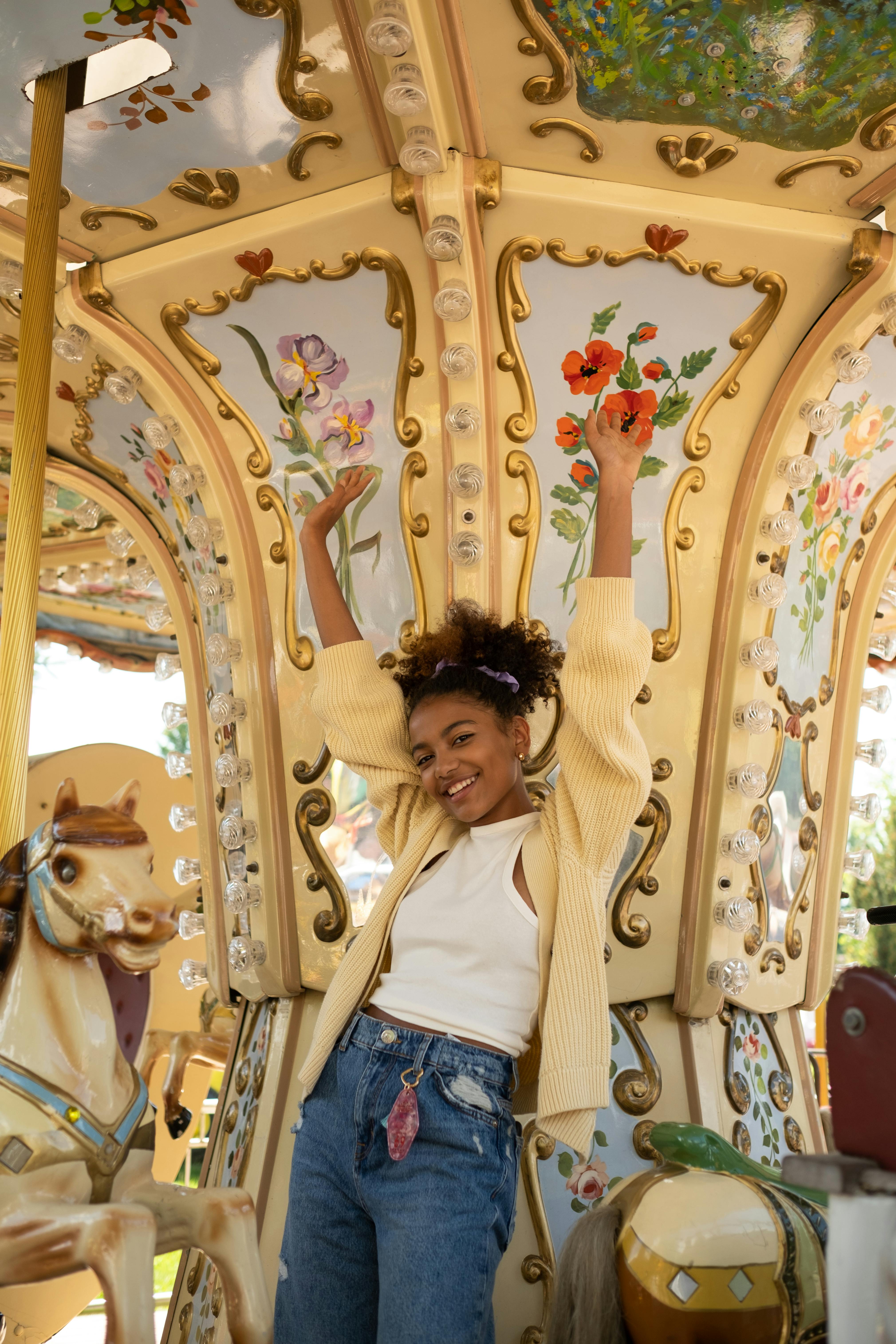 Cute black teenage girl sitting in carousel seat with eyes closed and ...