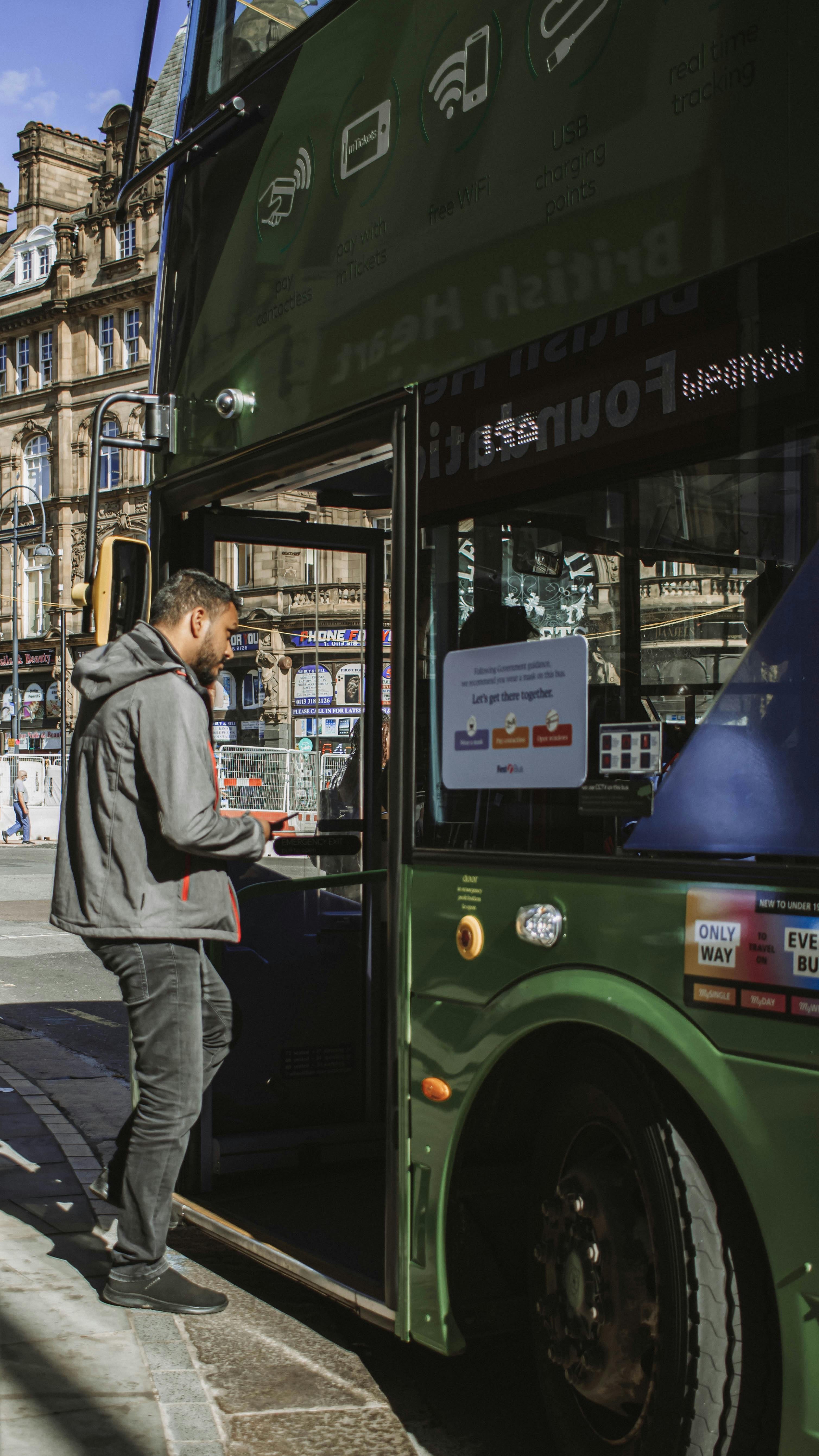 Photo of a Man Entering a Green Bus · Free Stock Photo