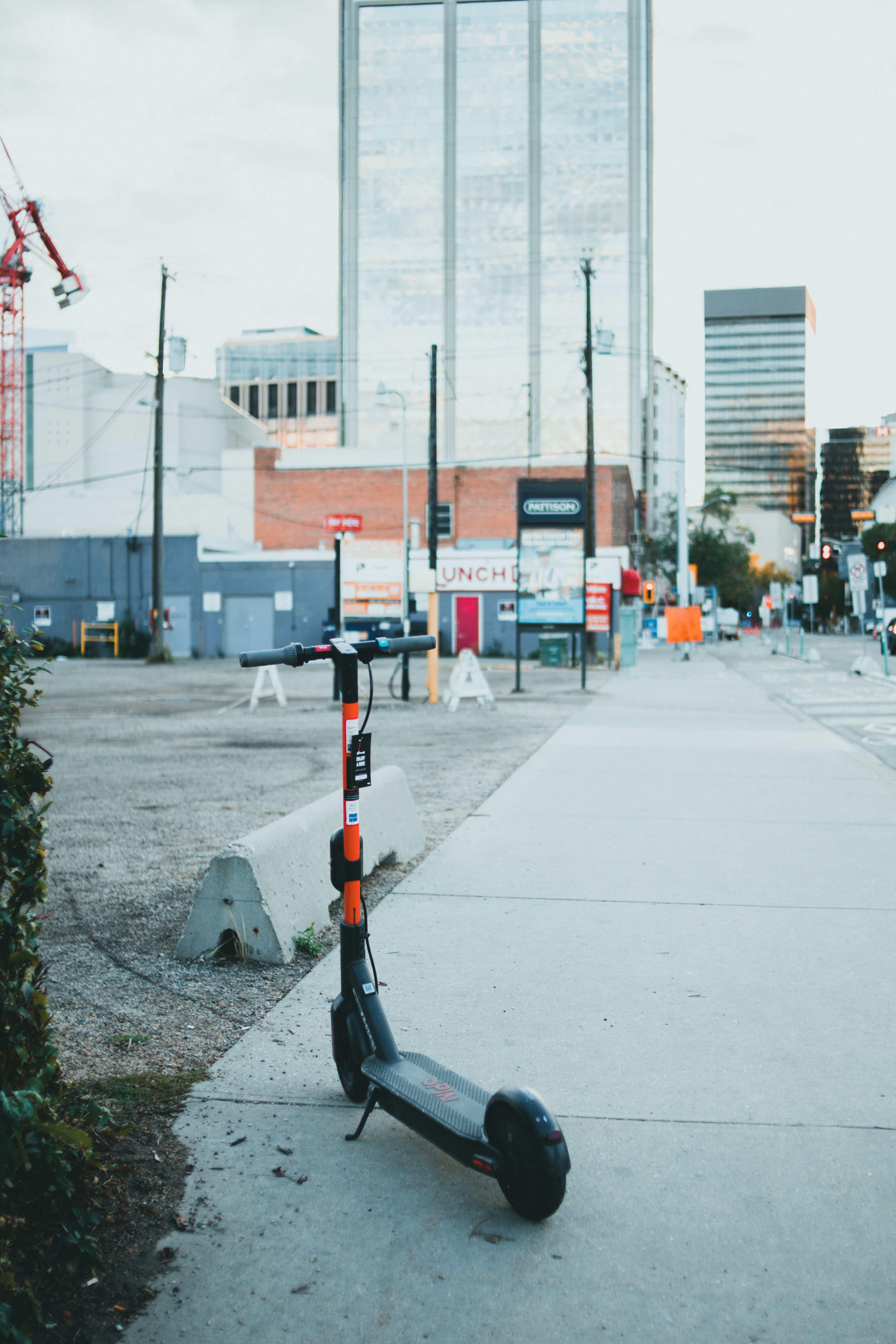 Electric Scooter Parked on Sidewalk · Free Stock Photo