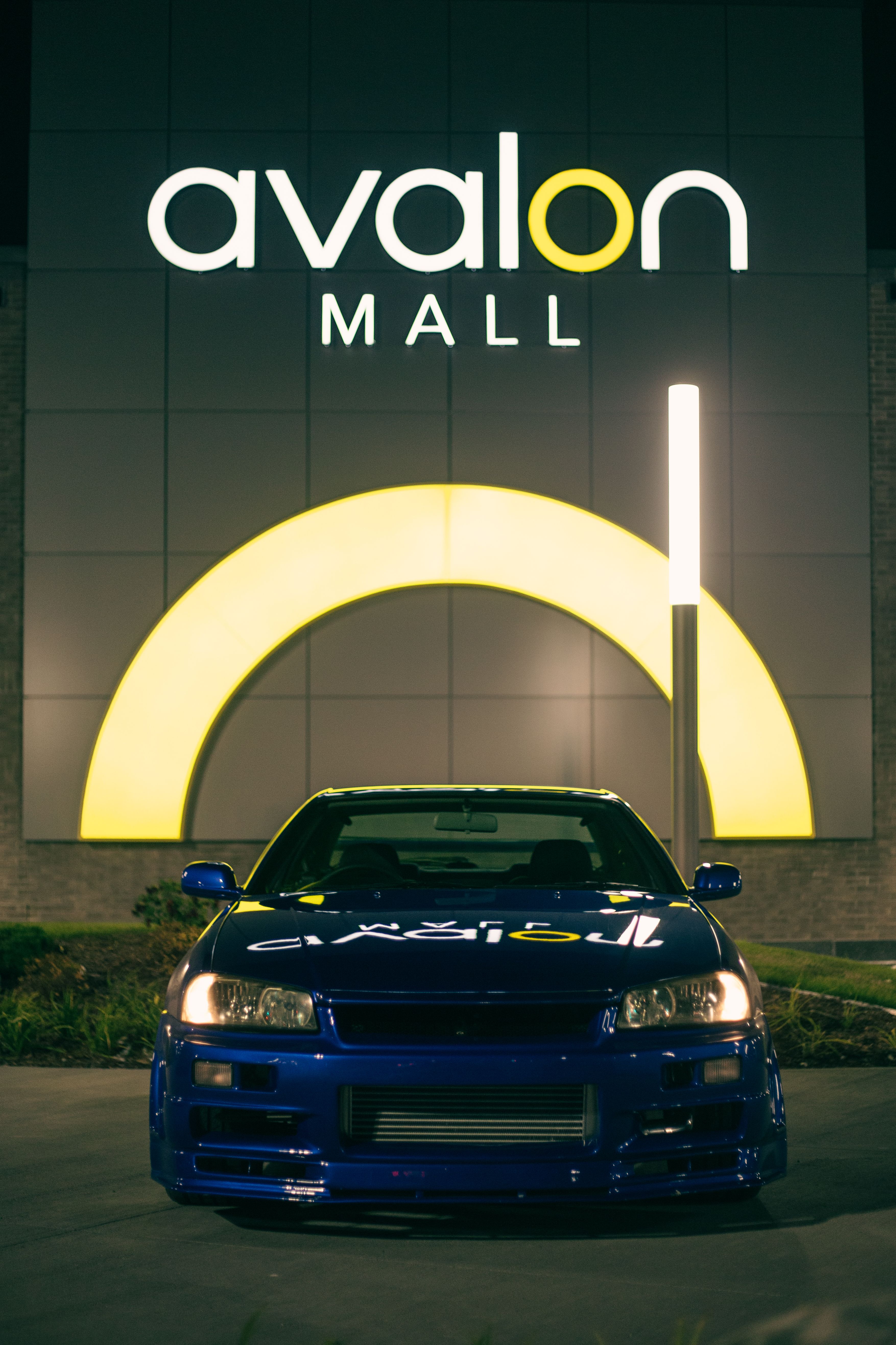 A Blue Shiny Car Parked Outside a Mall · Free Stock Photo