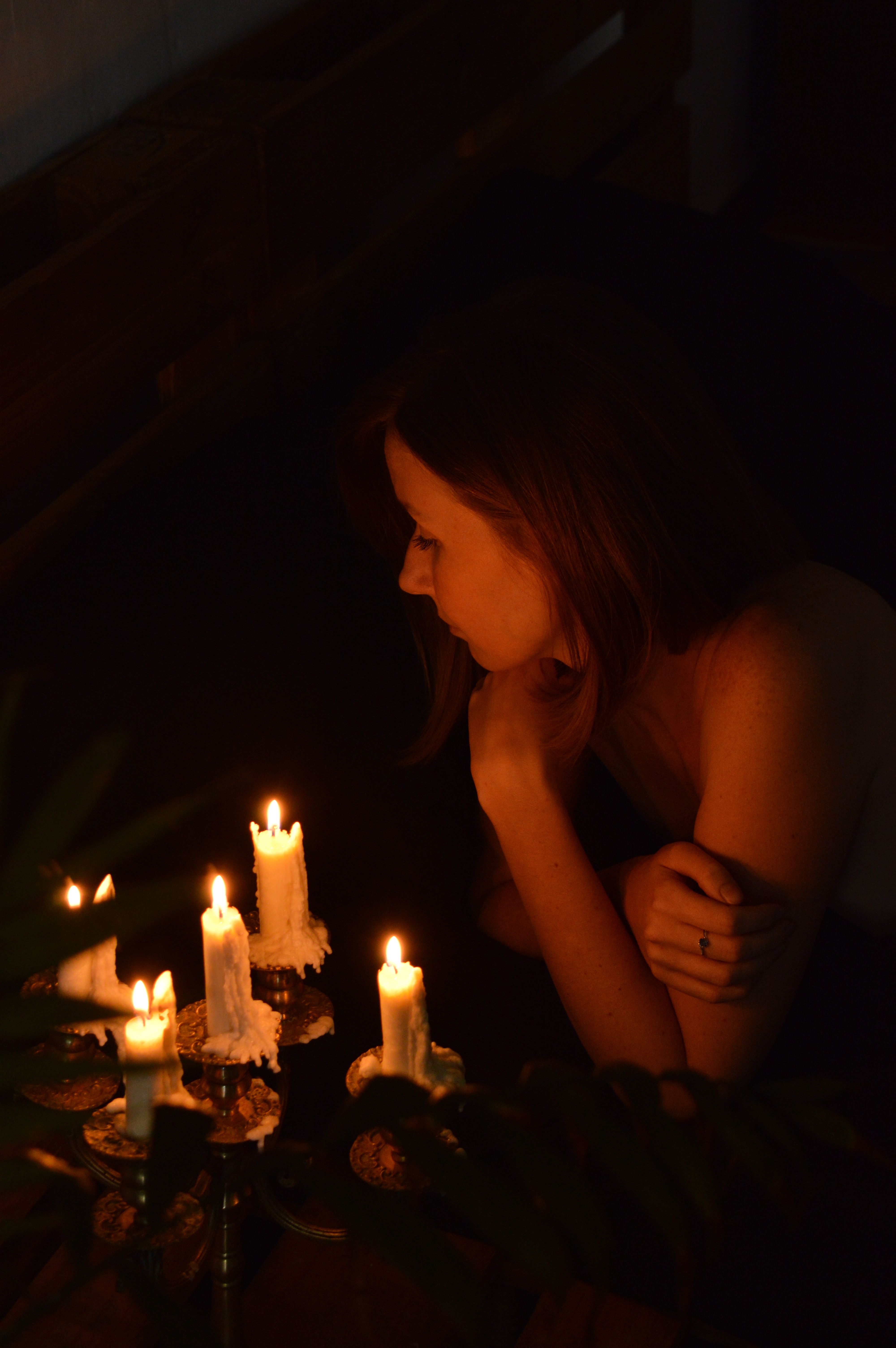 Woman Standing with a Burning Candle in her Hands in a Dark Room · Free ...