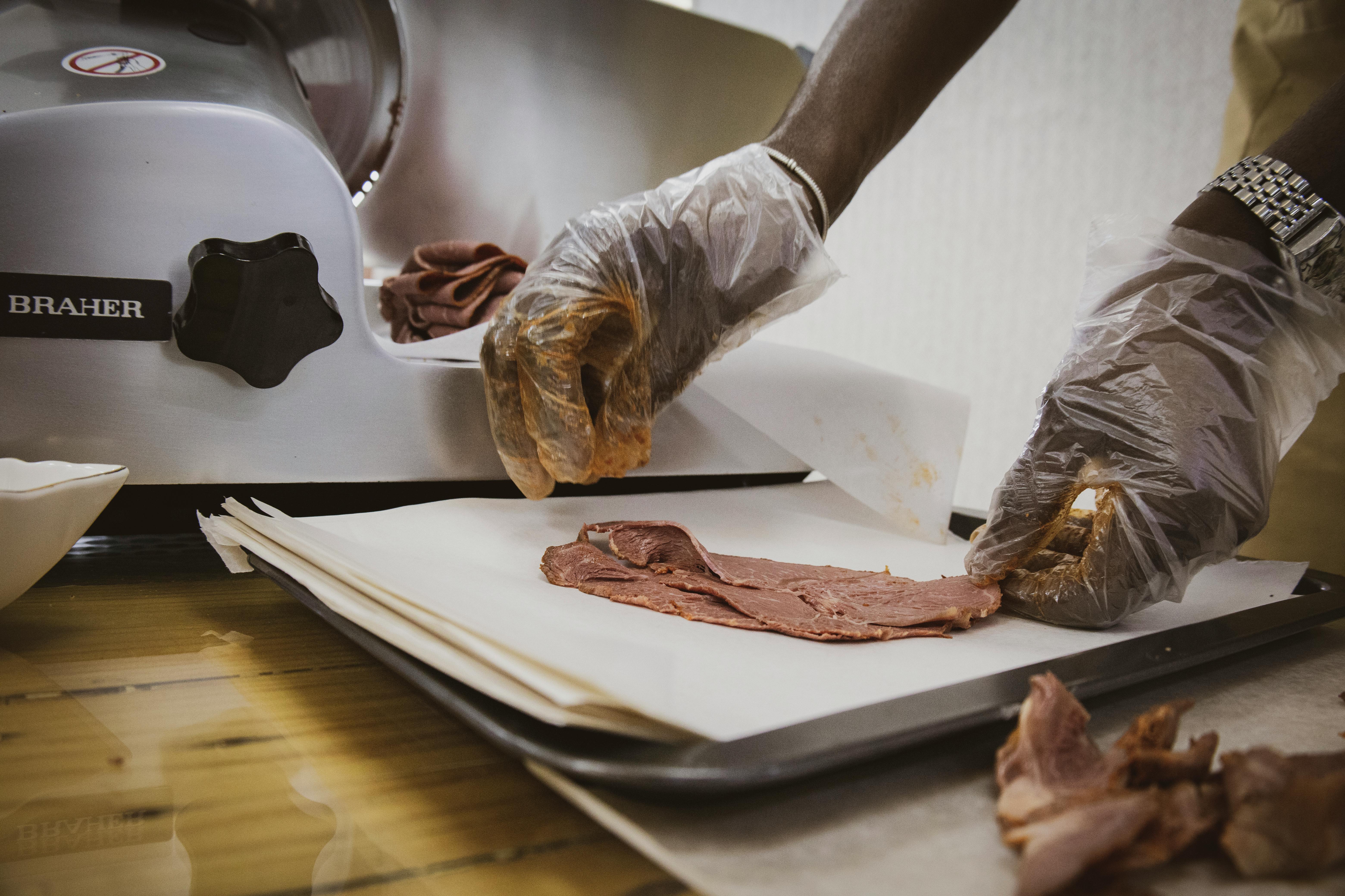 Person Slicing Meat · Free Stock Photo