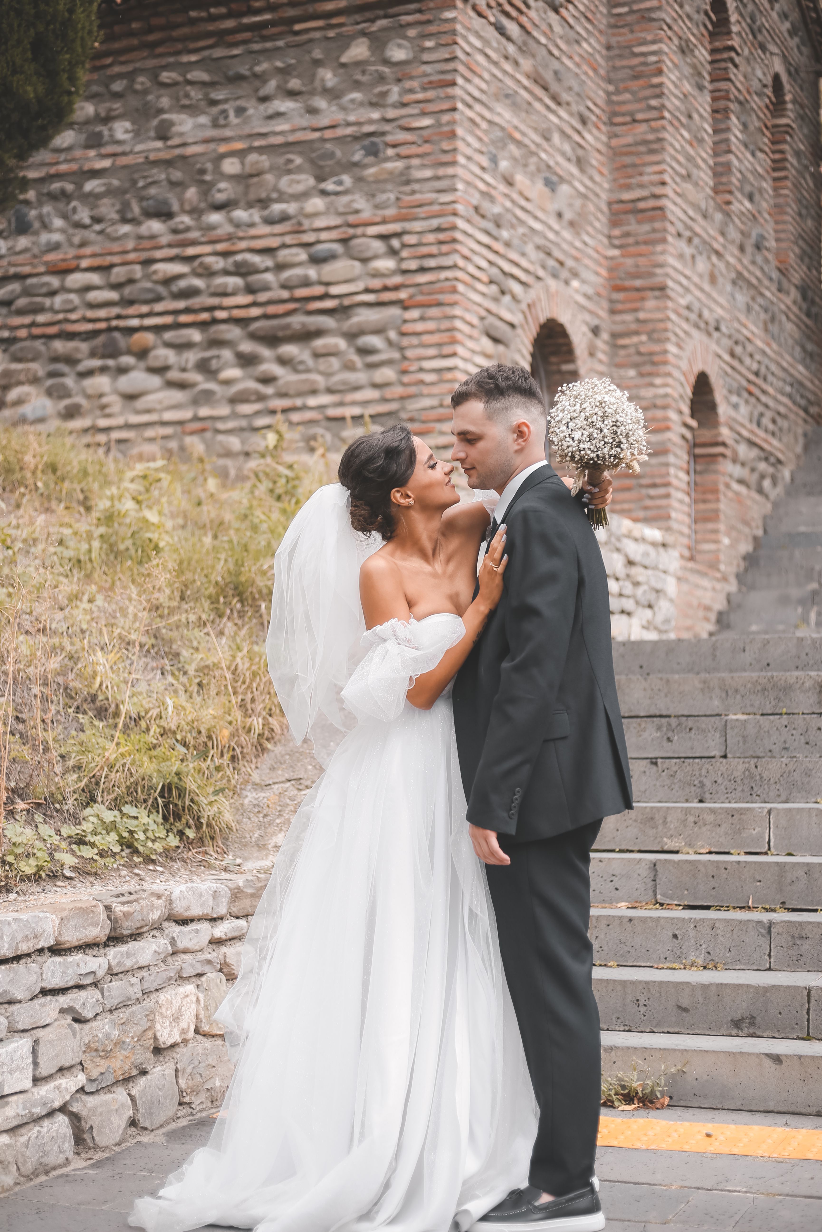 Wedding Couple Holding Hands on Bouquet of Roses · Free Stock Photo