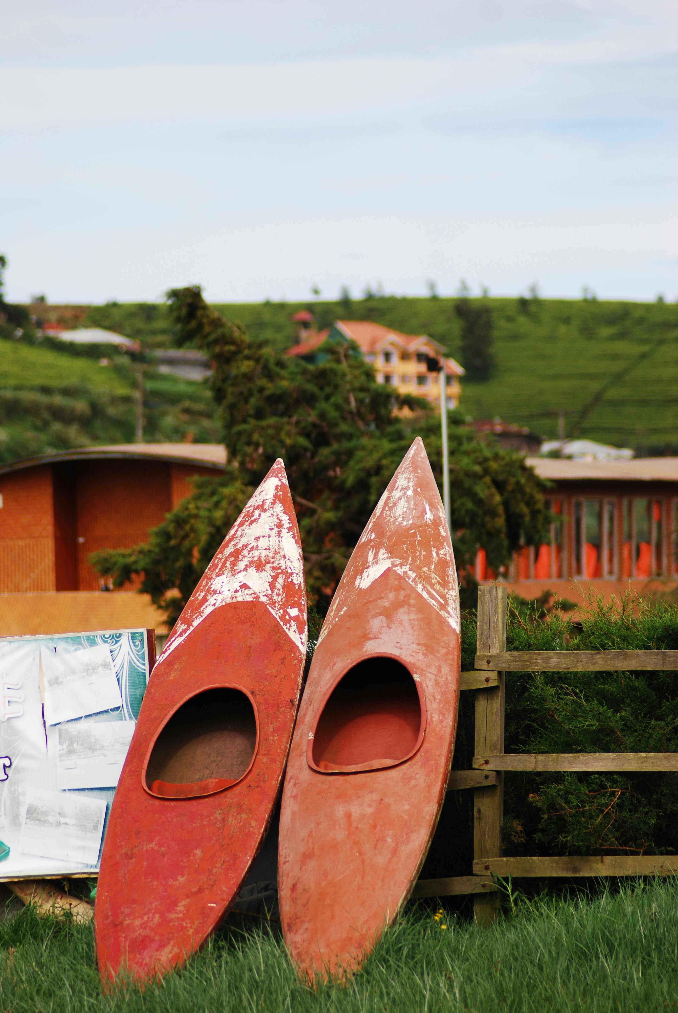 A Pair of Brown Kayaks on Brown Wooden Fence · Free Stock Photo