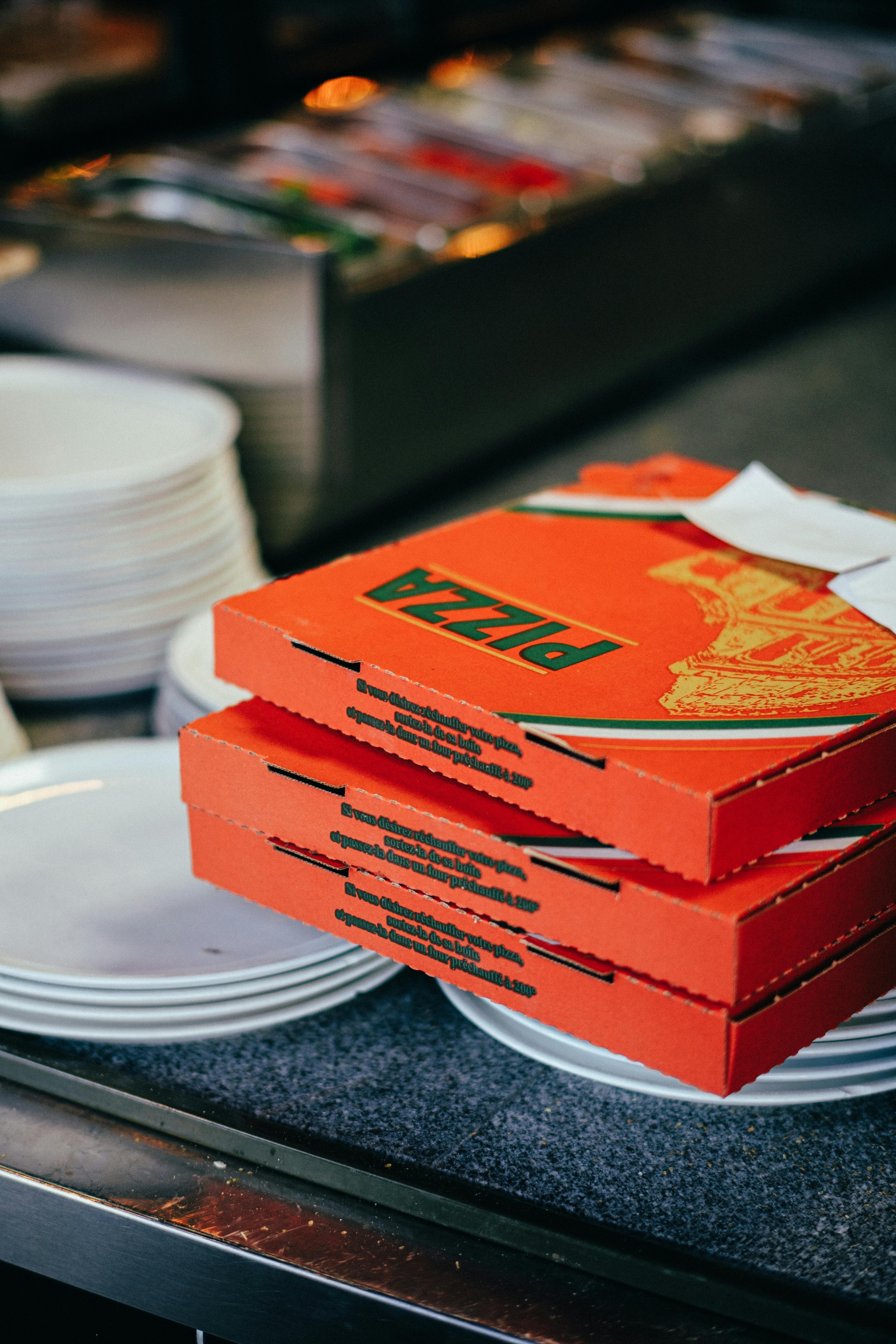 Pizza Boxes on Top of Ceramic Plates · Free Stock Photo