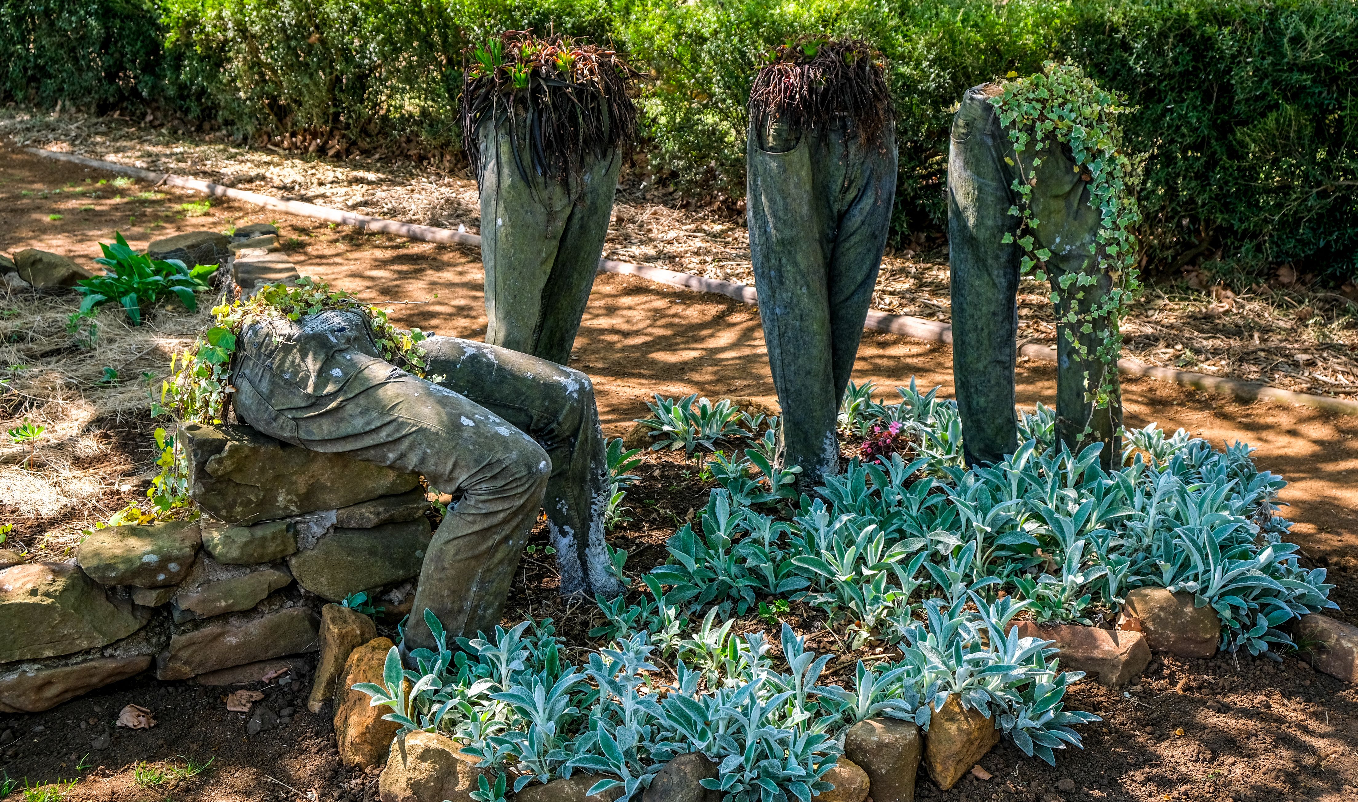 Statues of Standing and Sitting Legs in Garden · Free Stock Photo