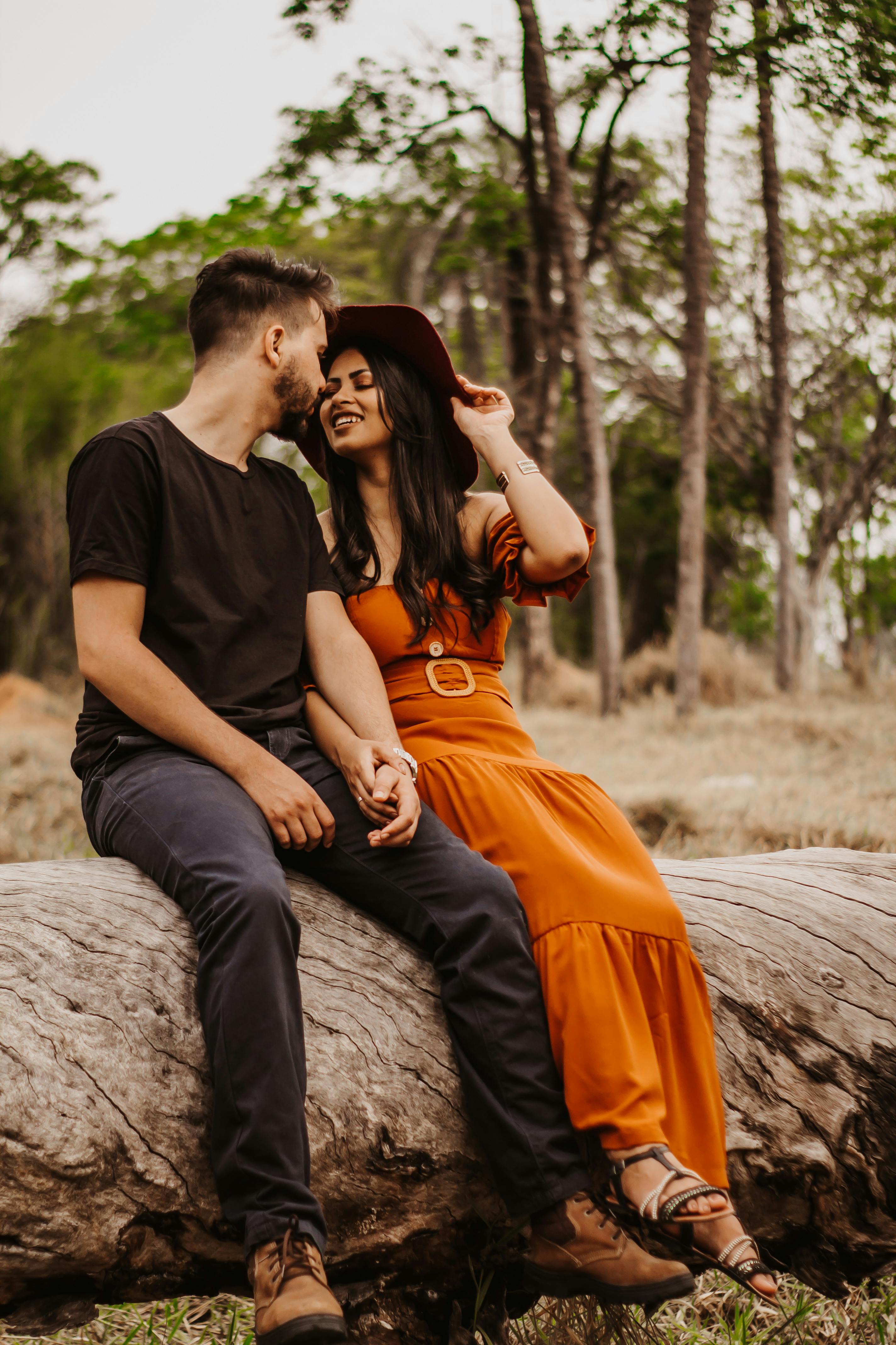 A Man in Black Shirt and Woman in Orange Dress Kissing · Free Stock Photo